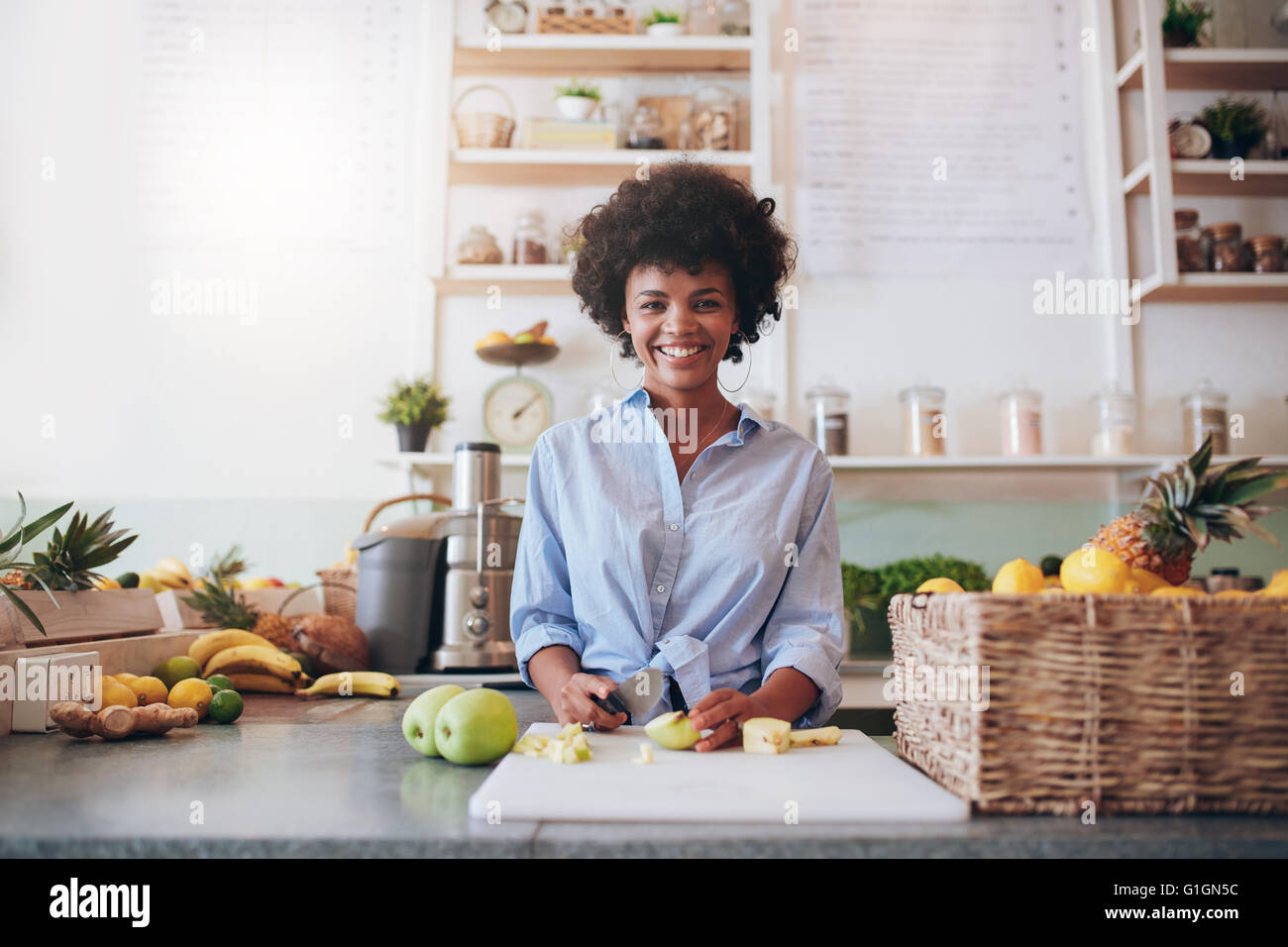 Portrait of beautiful young african woman standing behind the bar ...