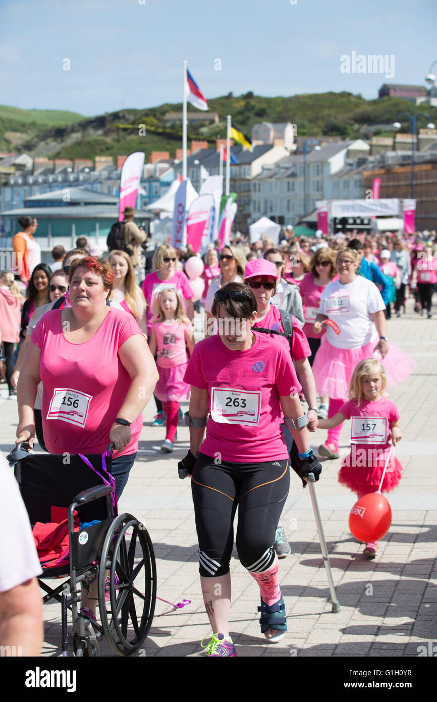 A woman on crutches taking part of the annual cancer research charity ...