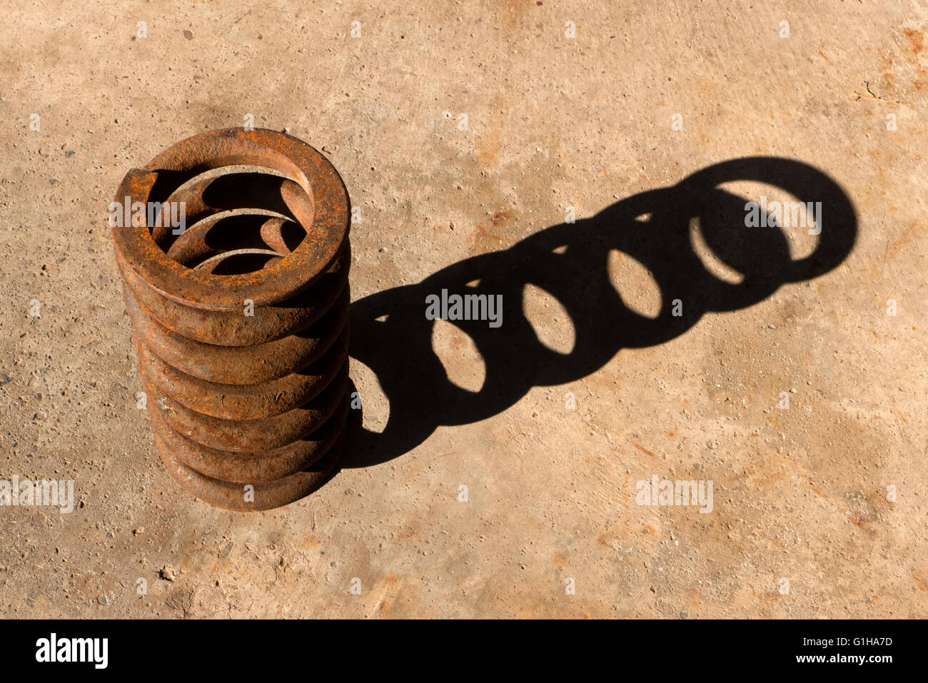 Large rusty spring casts a shadow Stock Photo - Alamy