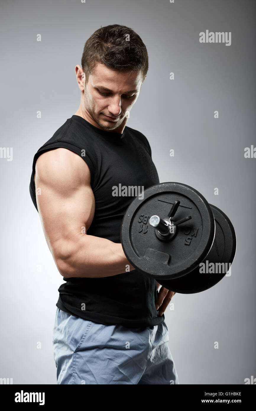 Athlete doing biceps curl with dumbbells, studio shot Stock Photo - Alamy