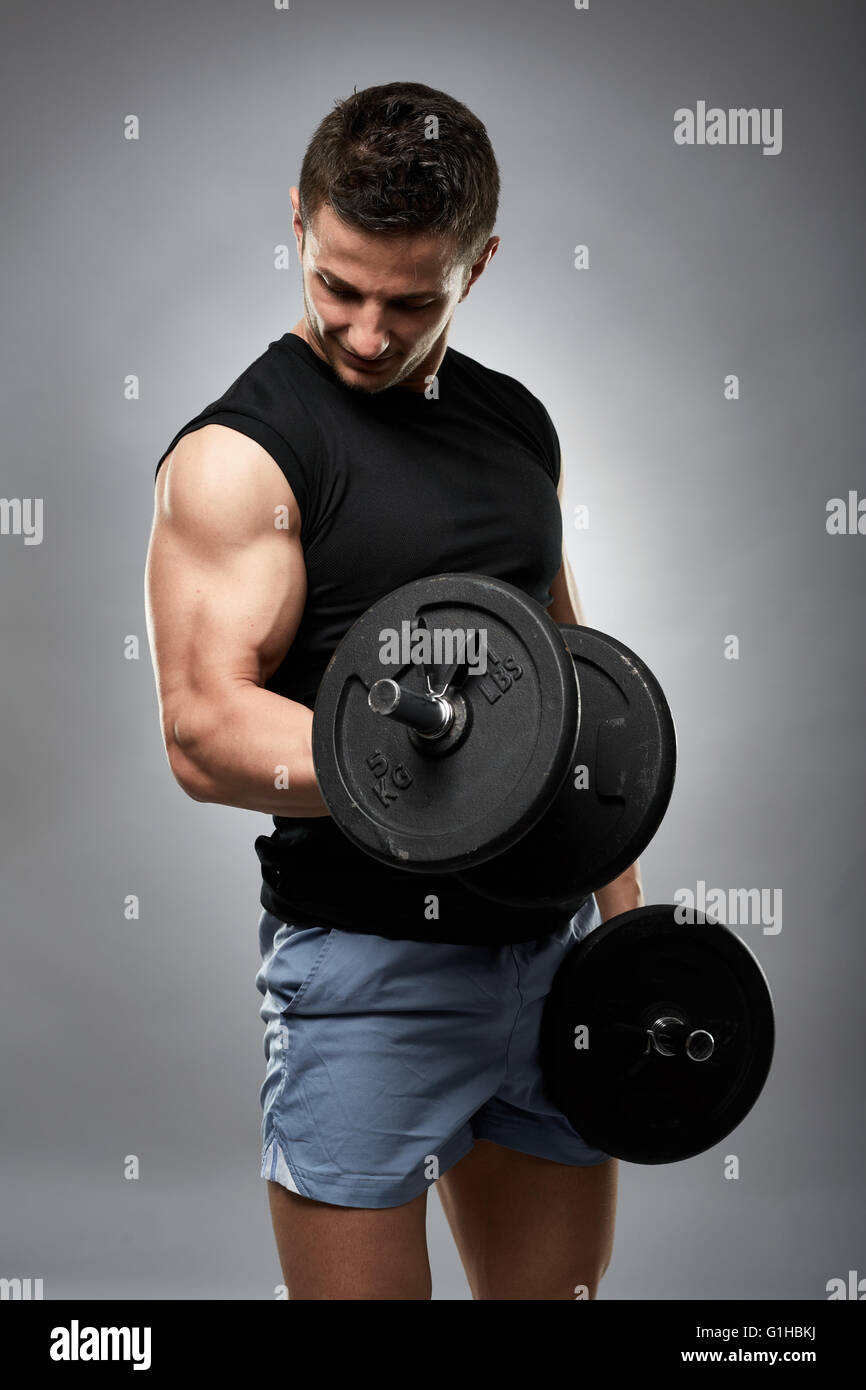 Athlete doing biceps curl with dumbbells, studio shot Stock Photo - Alamy