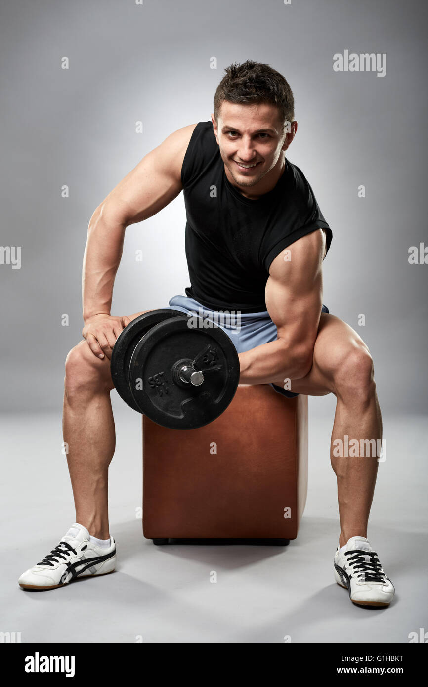 Man doing biceps curl in seated position, studio shot Stock Photo - Alamy