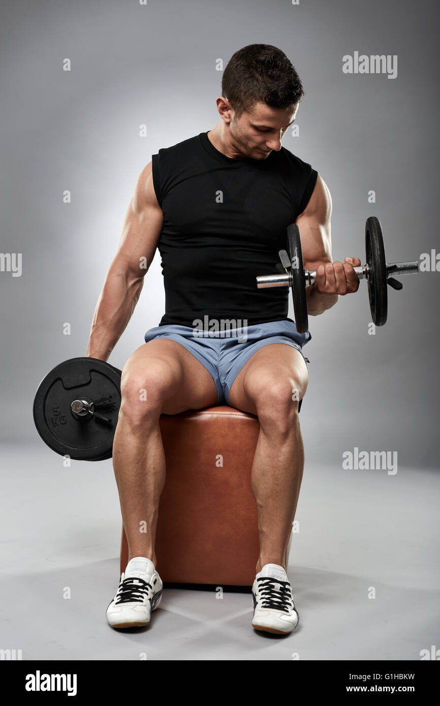 Man doing biceps curl in seated position, studio shot Stock Photo - Alamy