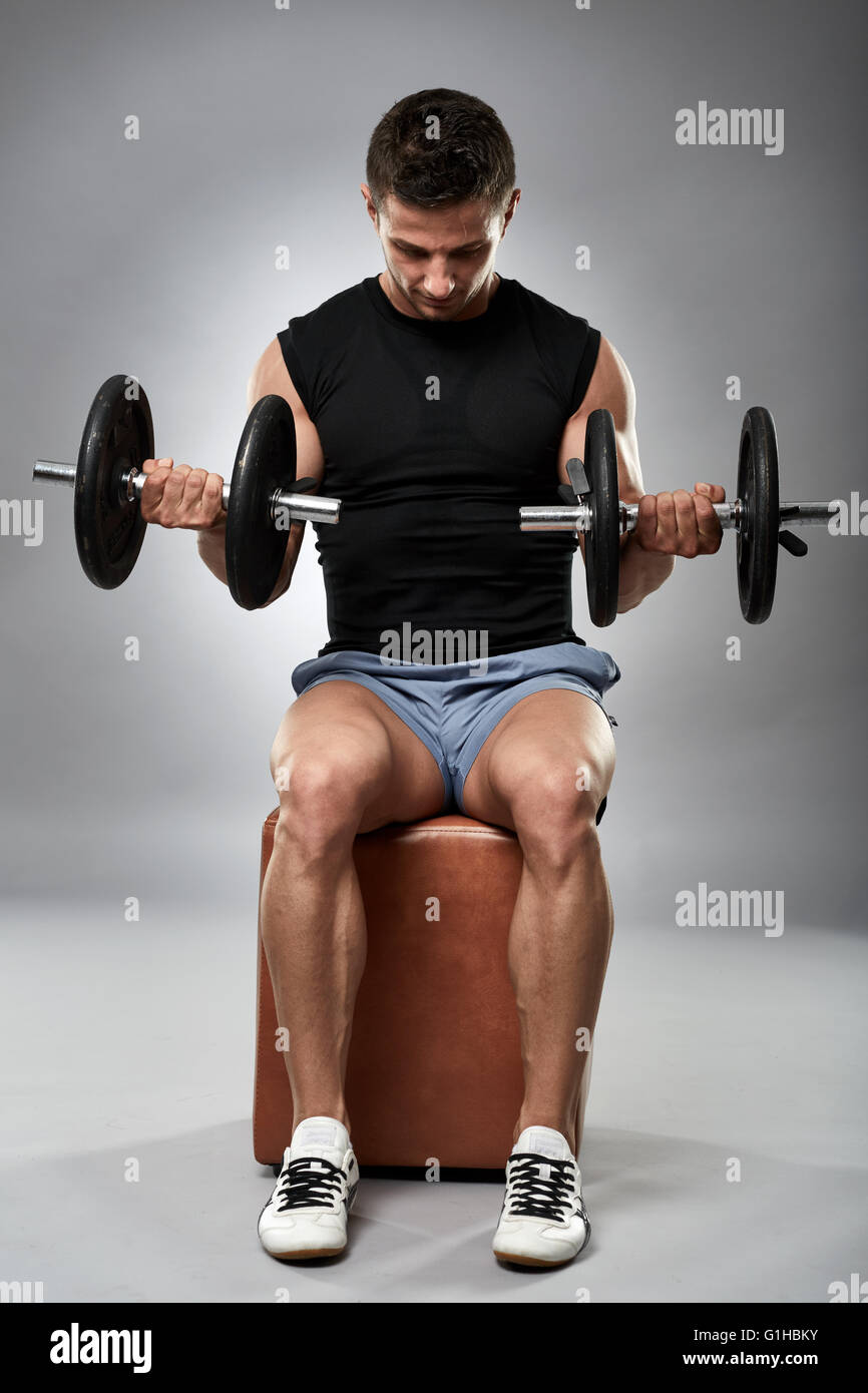Man doing biceps curl in seated position, studio shot Stock Photo - Alamy