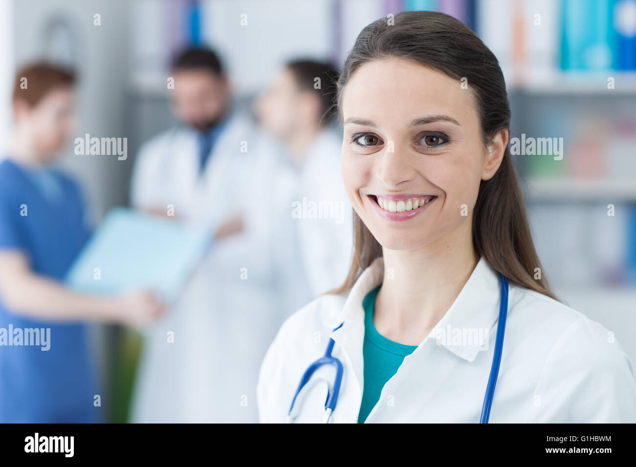Smiling female doctor posing in the office and looking at camera ...