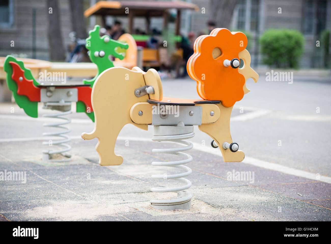 Colorful swings in a kids playground. Lion and dragon shaped Stock ...