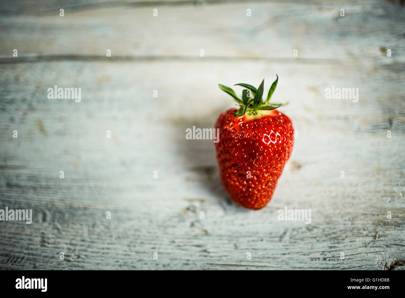Single fresh red strawberry on simple background Stock Photo - Alamy