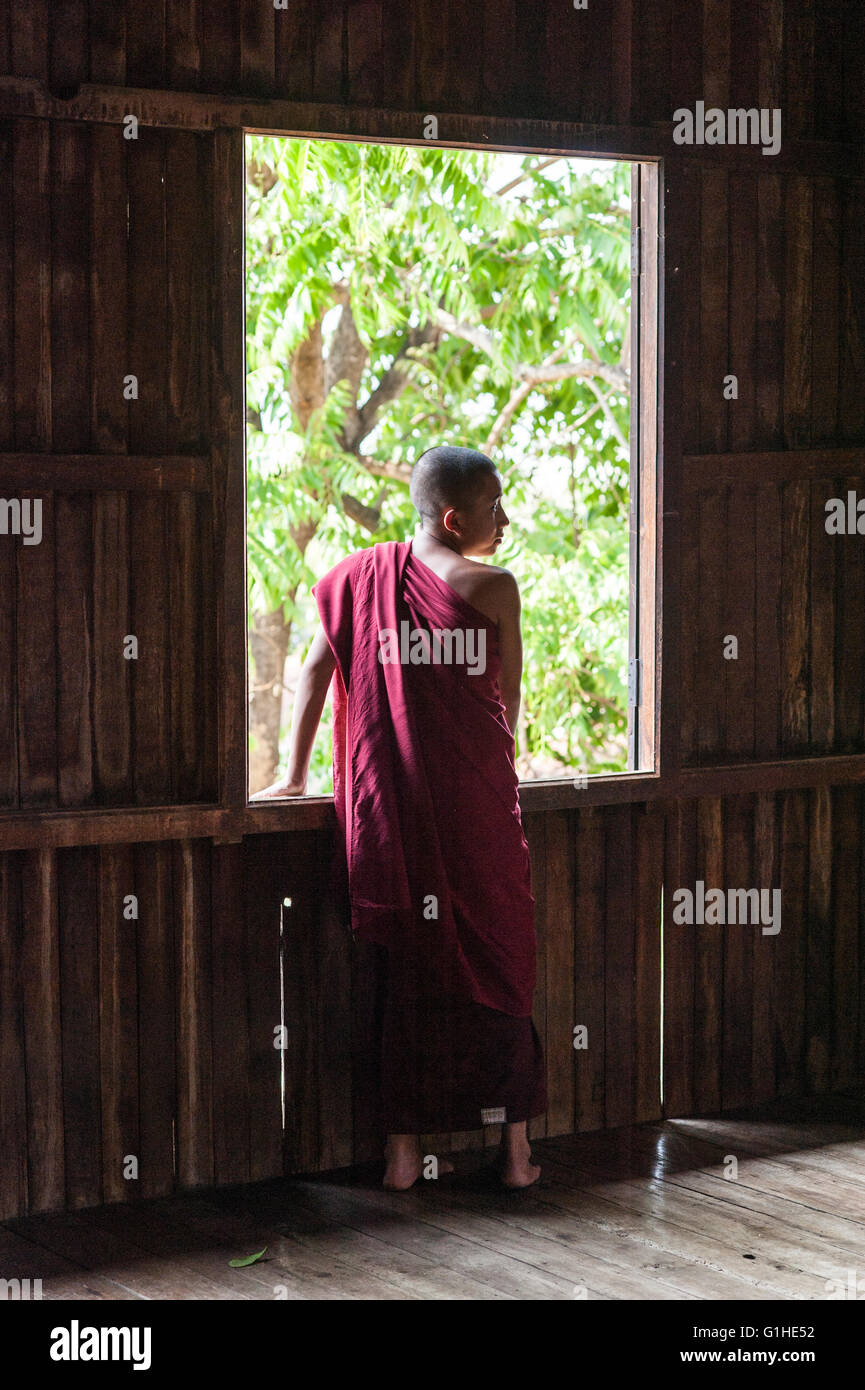Burmese Buddhist monk standing by the window in a monastery. Buddhist ...