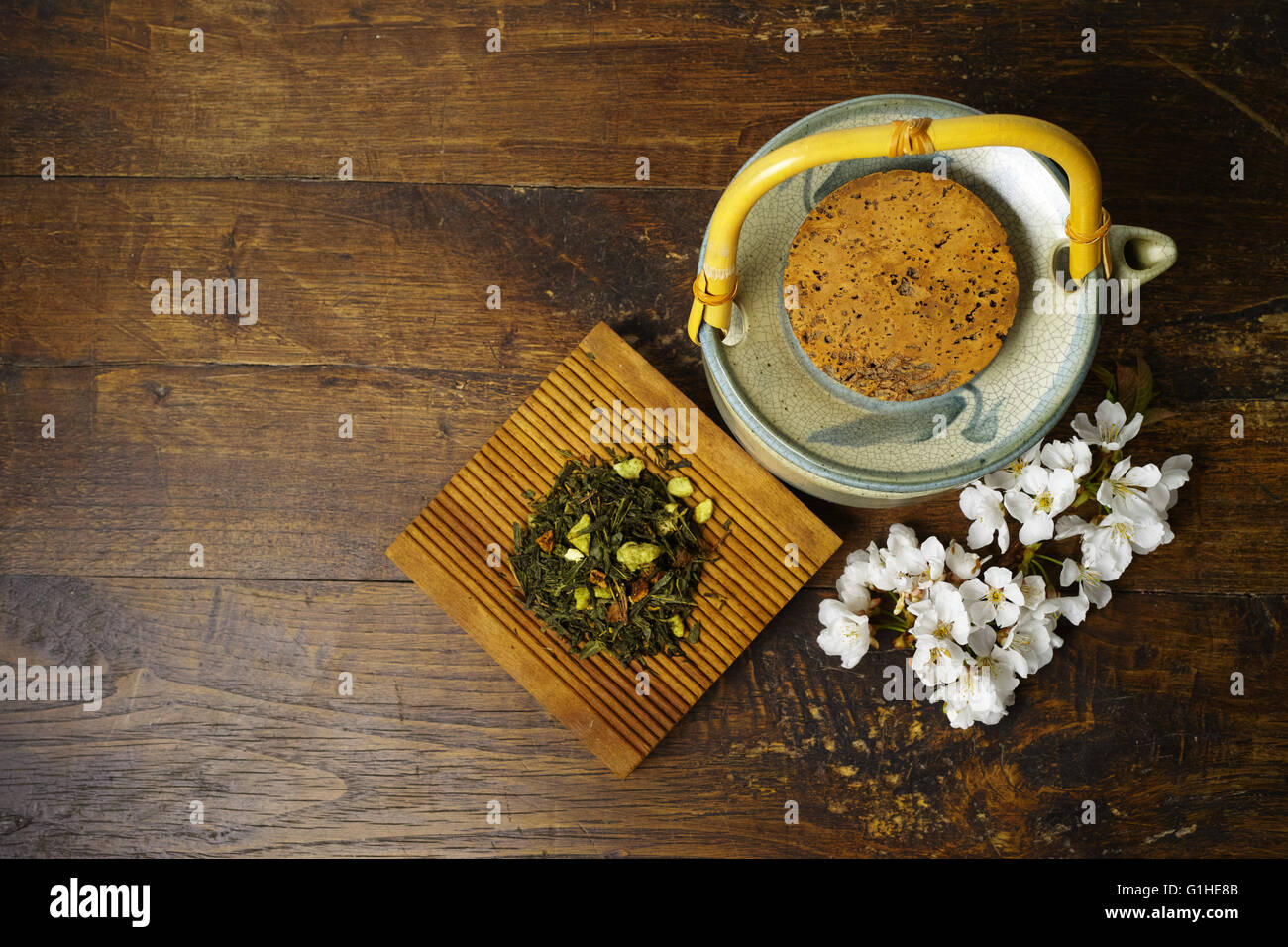 Japan's teapot with green tea on wooden plank and sakura flowers on ...
