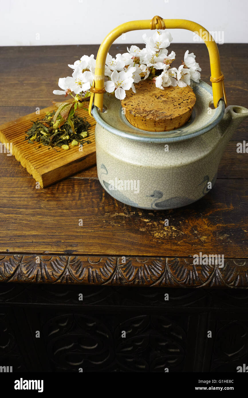 Japan's teapot with green tea on wooden plank and sakura flowers on ...