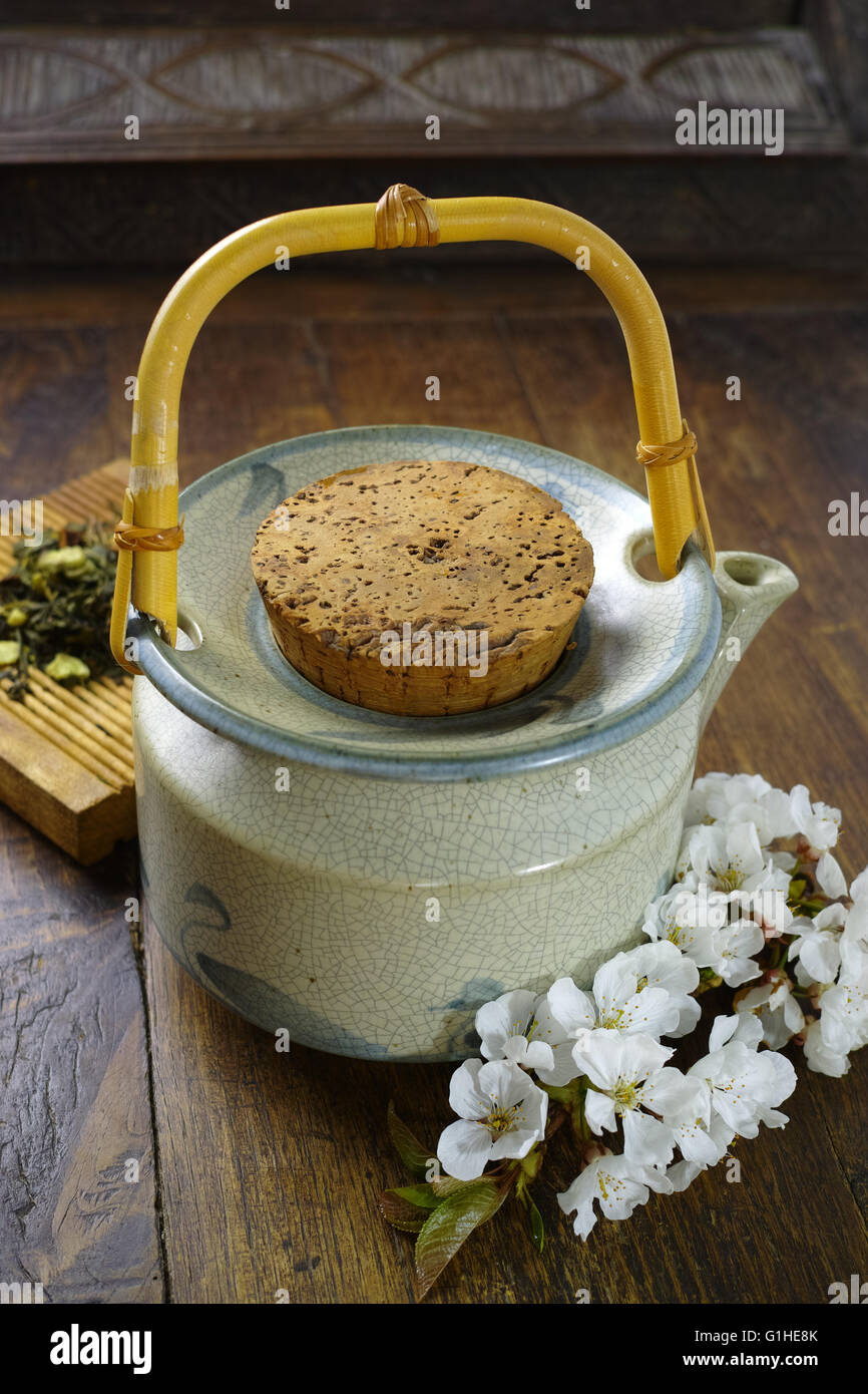 Japan's teapot with green tea on wooden plank and sakura flowers on ...
