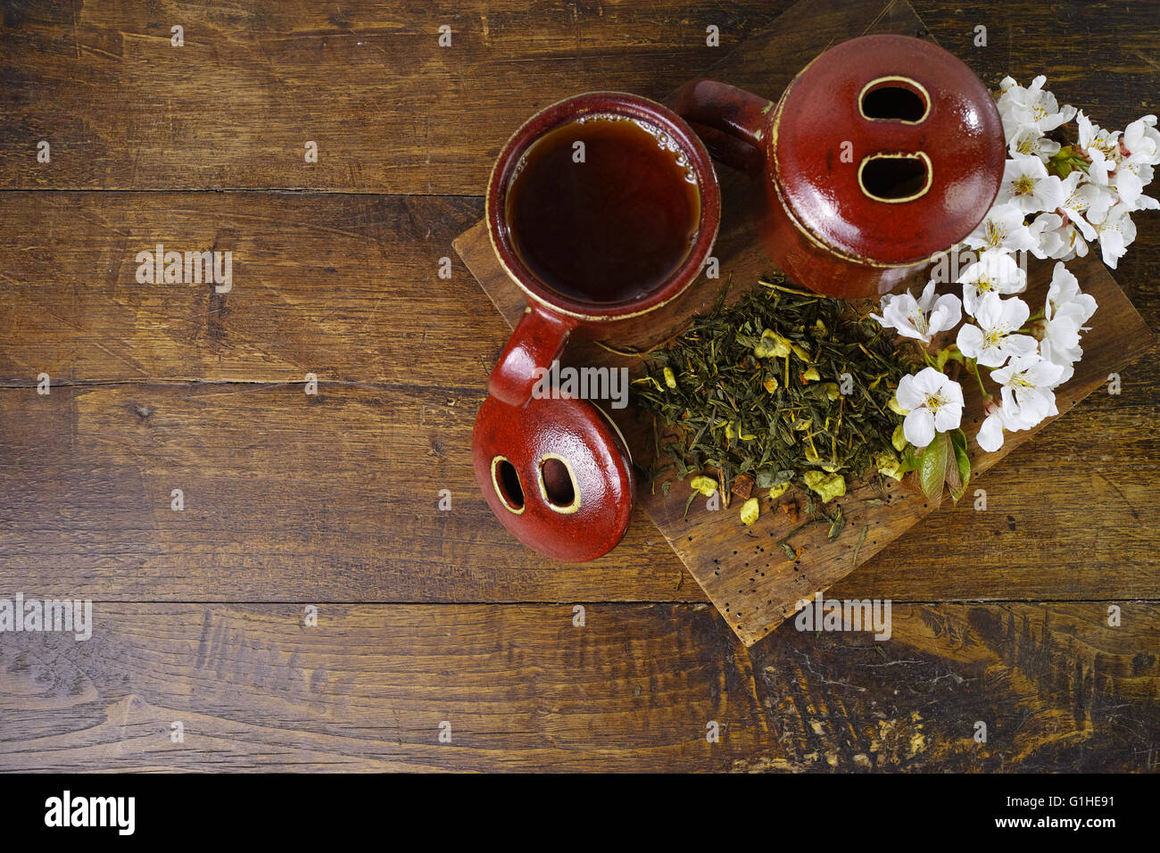 Japan's tea cups with green tea on wooden plank and sakura flowers on ...