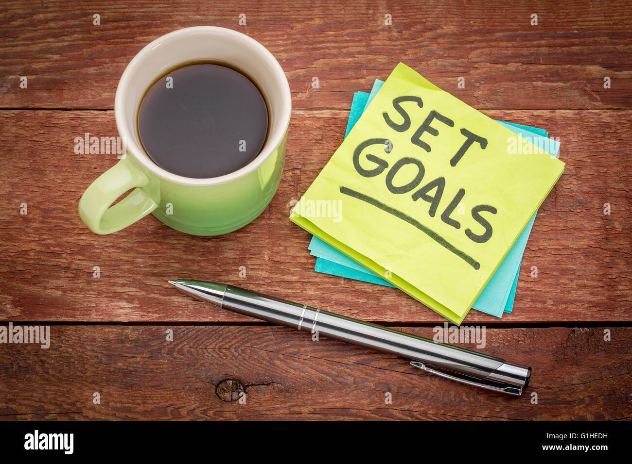 set goals reminder on a sticky note with a pen and a cup of coffee ...