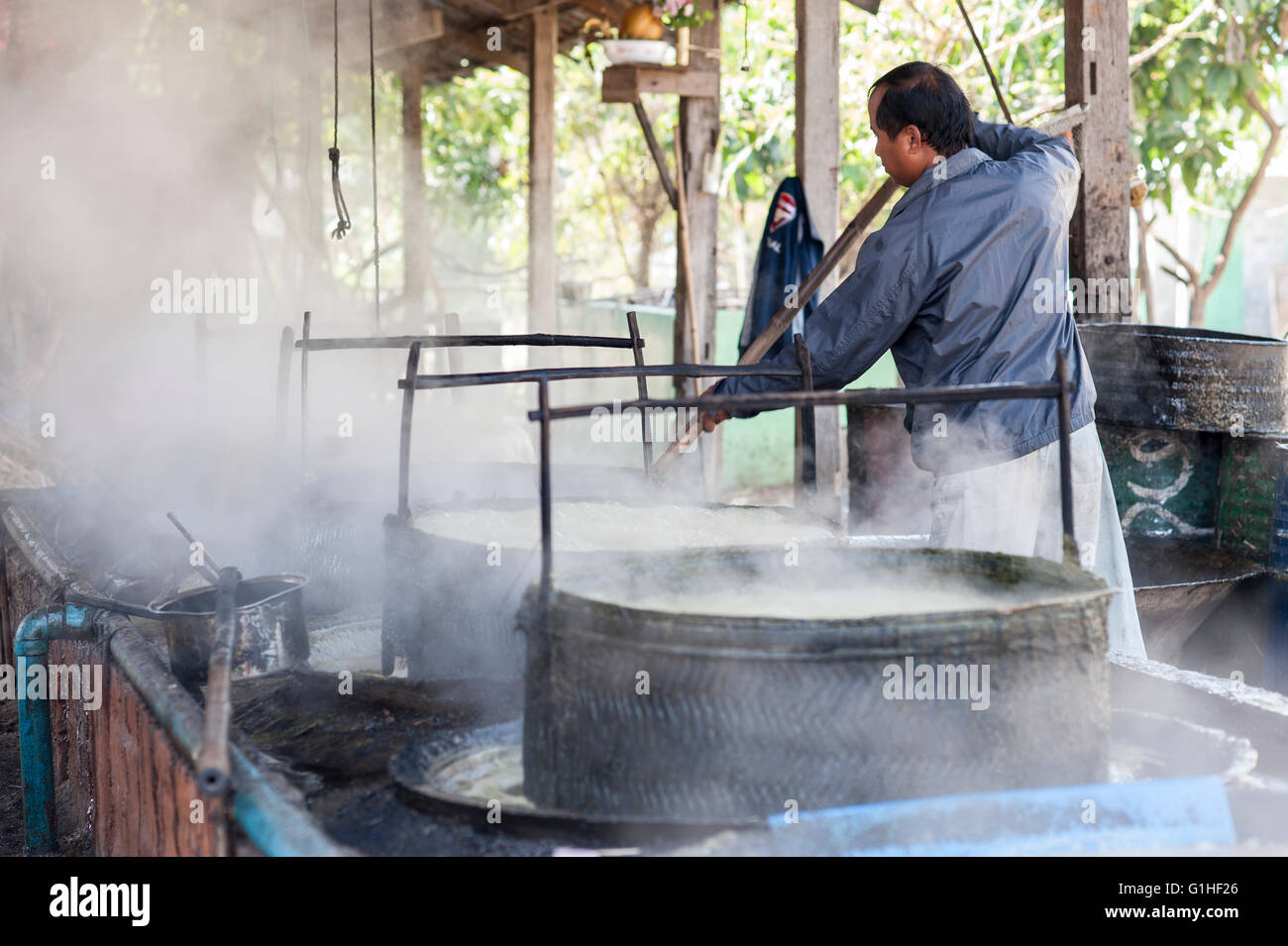 Burmese farmer working on a sugar cane farm. Man cooking sugar cane ...