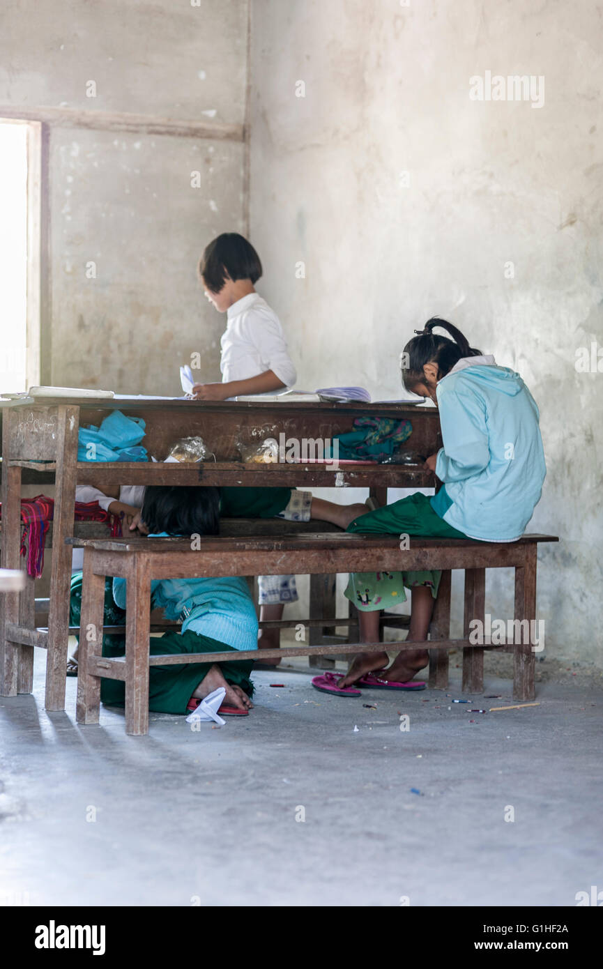 School girls playing at a school table in a small classroom on Inle ...