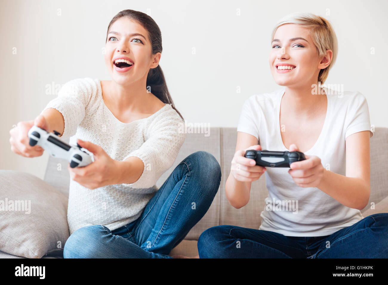 Two happy women playing video games Stock Photo - Alamy