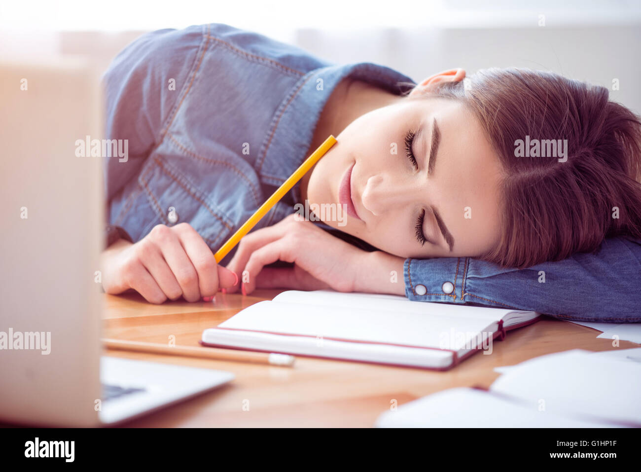 Positive woman sleeping at the table Stock Photo - Alamy