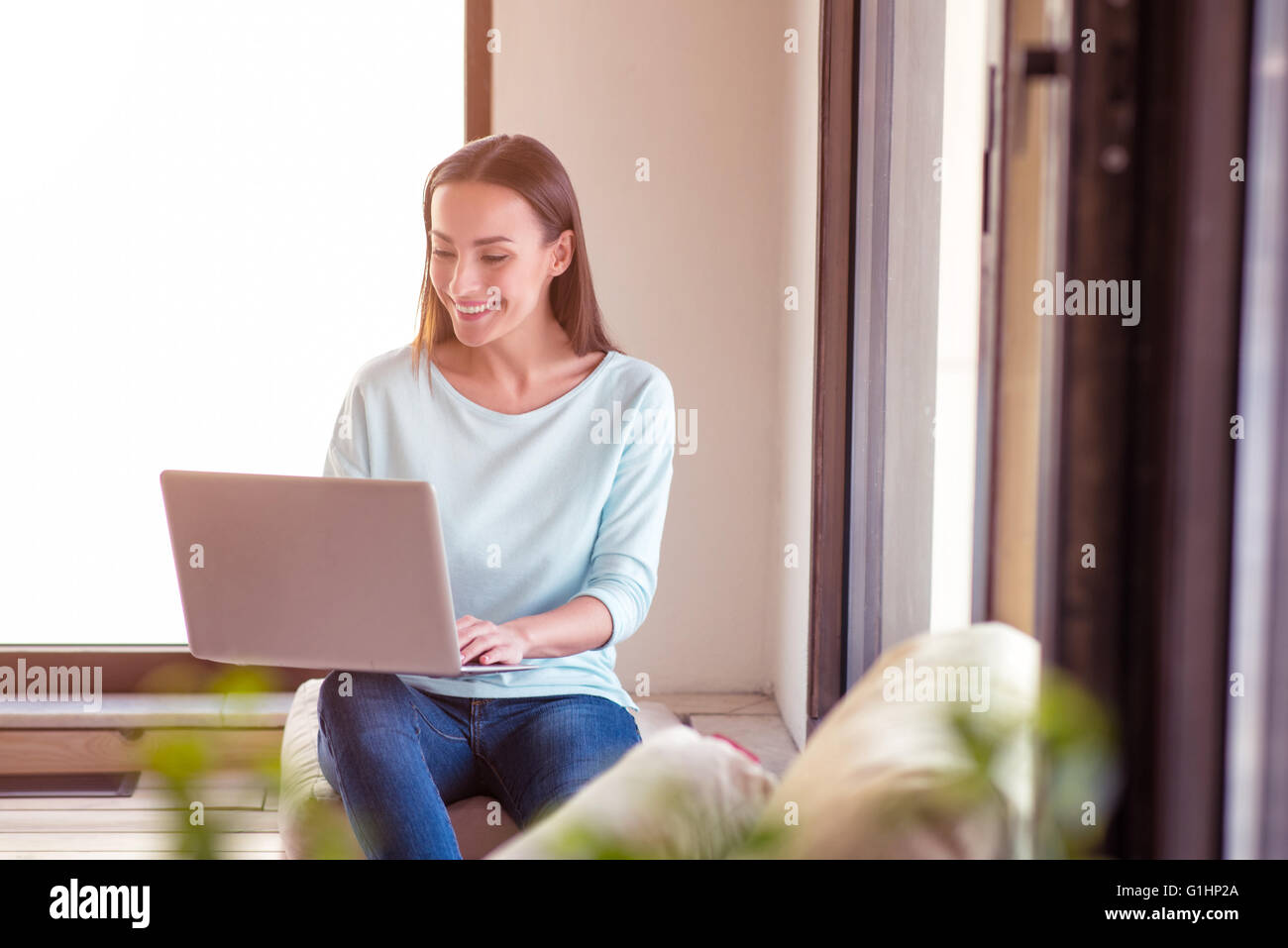 Positive woman using laptop Stock Photo - Alamy