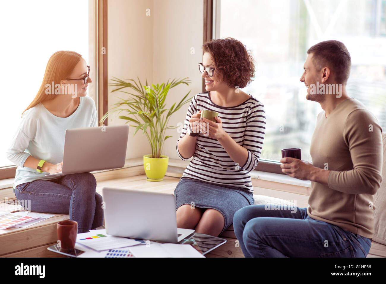 Cheerful colleagues drinking coffee in the office Stock Photo - Alamy