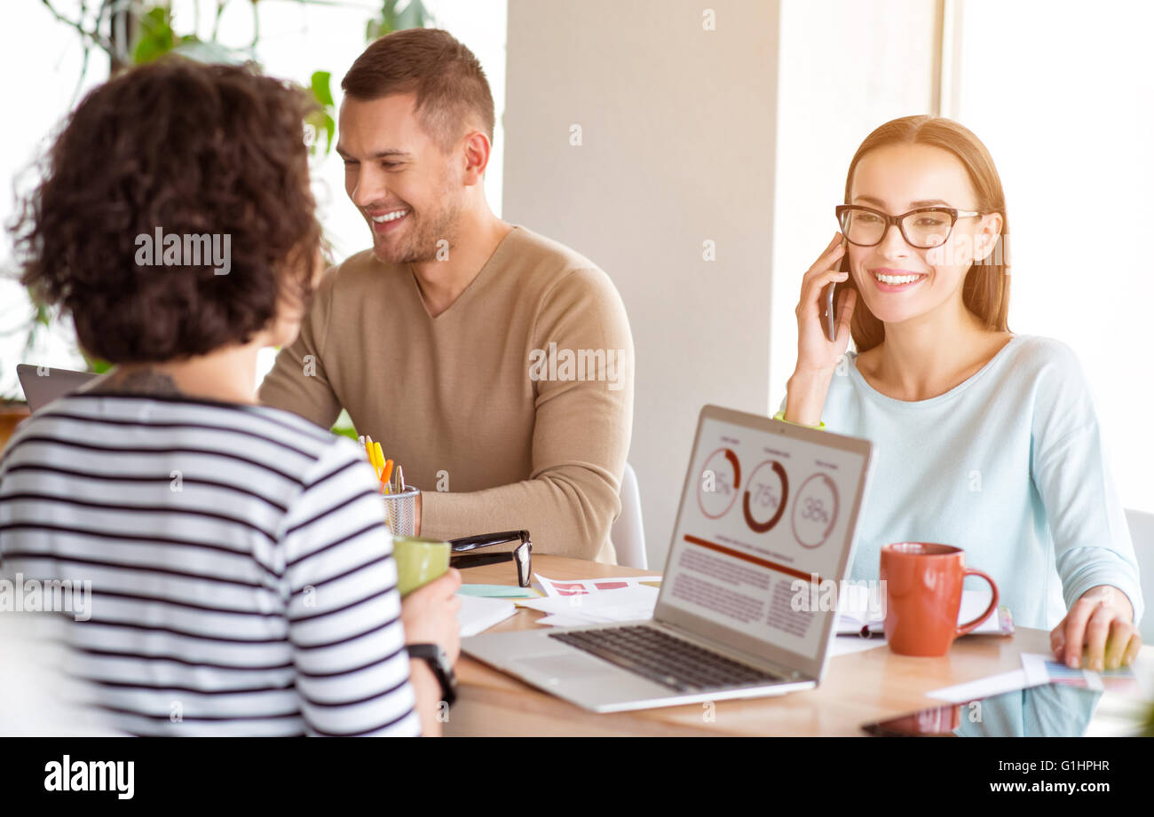 Beautiful woman sitting with her colleagues Stock Photo - Alamy