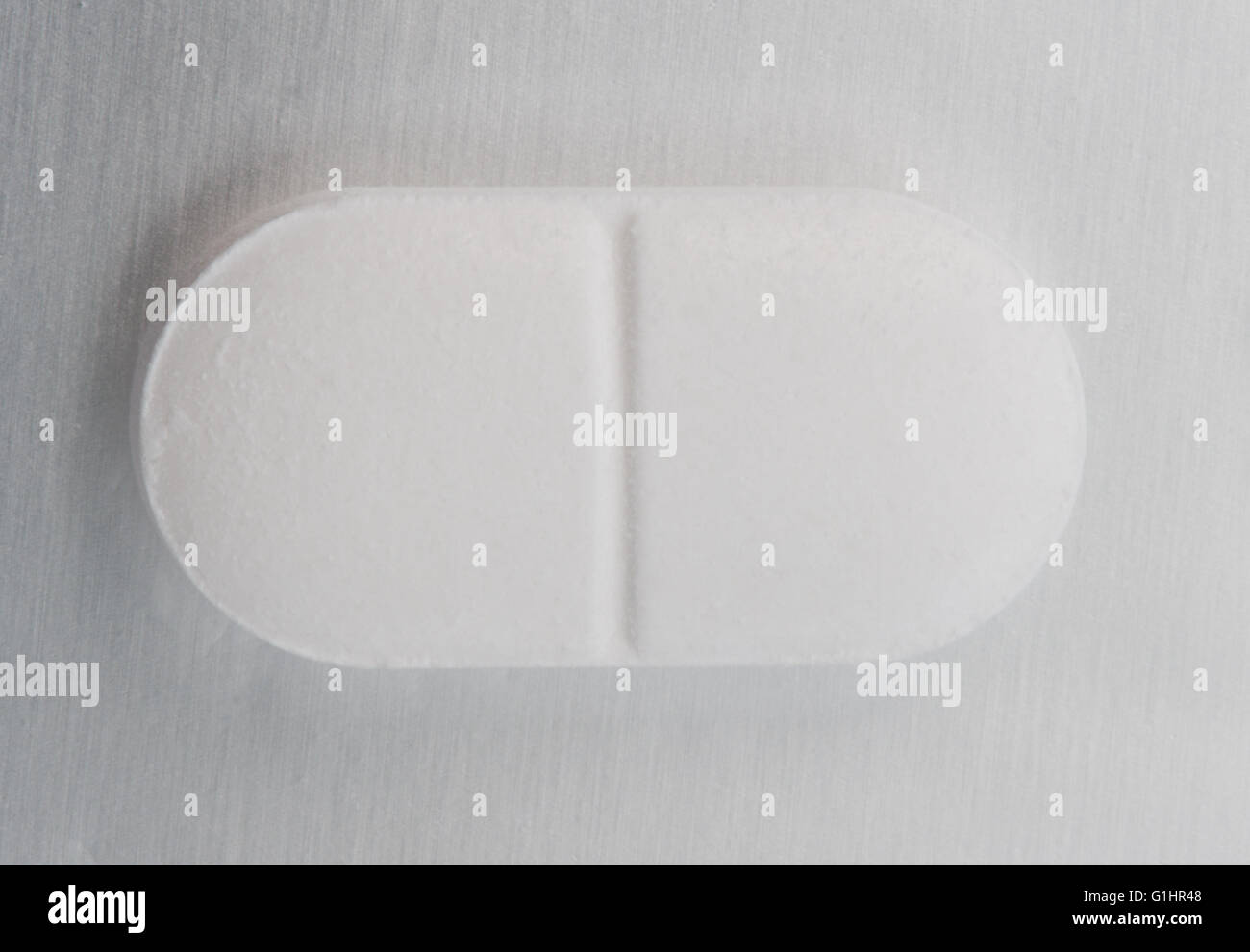 A single white painkilling tablet such as paracetamol showing its two ...