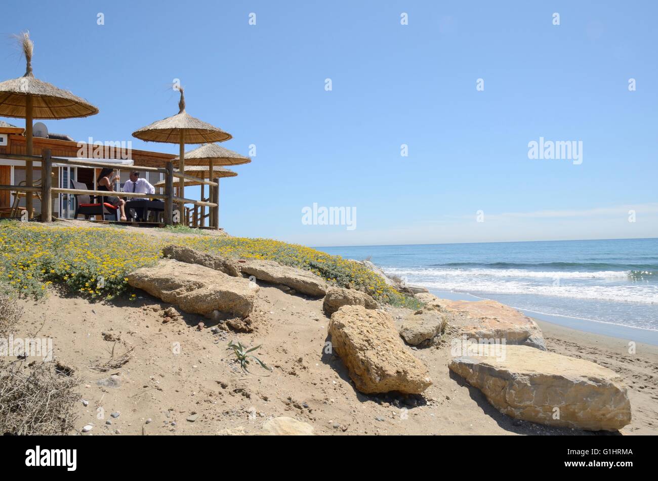 Couple having lunch at sun in the terrace of a beach bar in Marbella, a ...