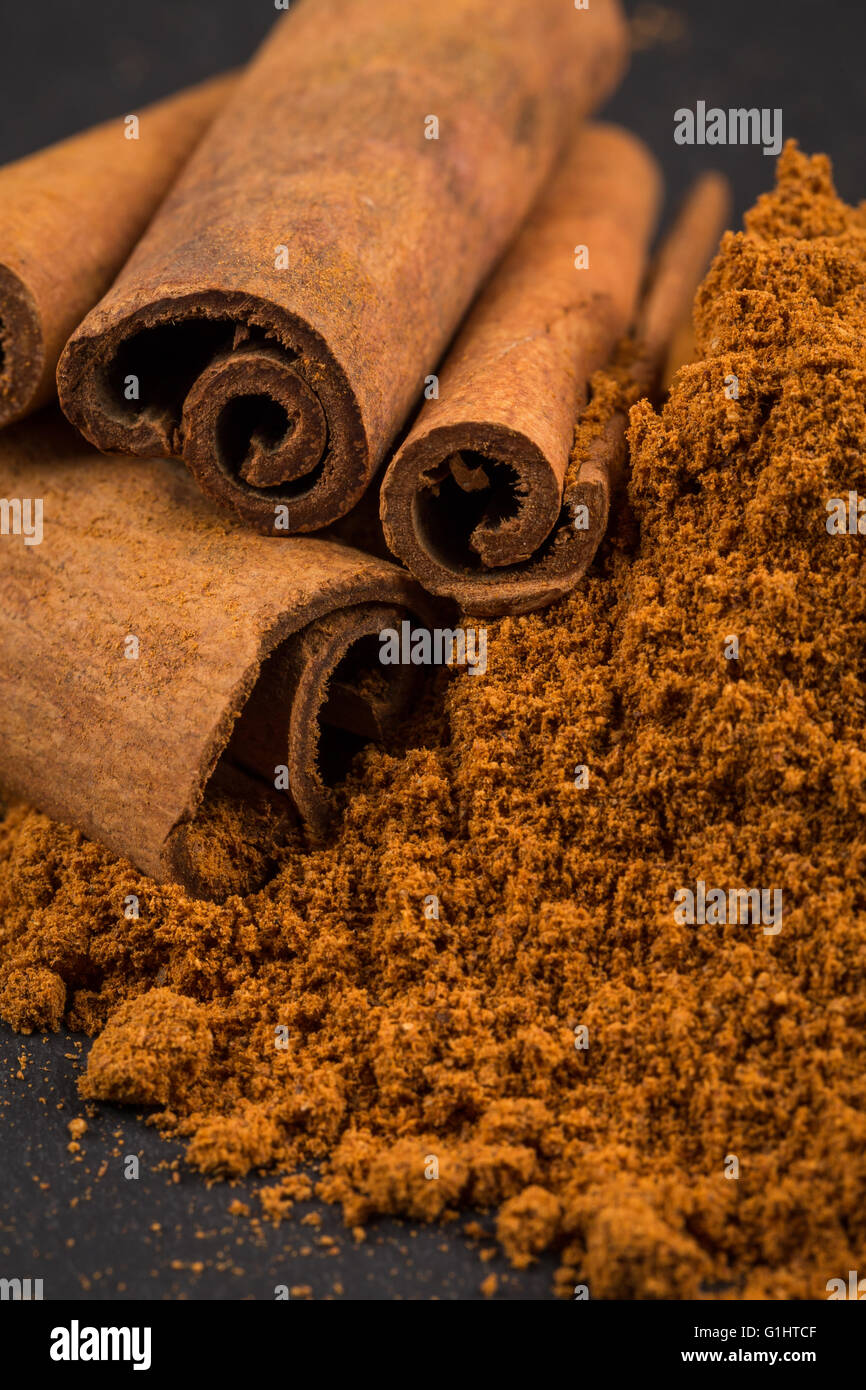 cinnamon sticks with powder on dark stone plate Stock Photo - Alamy