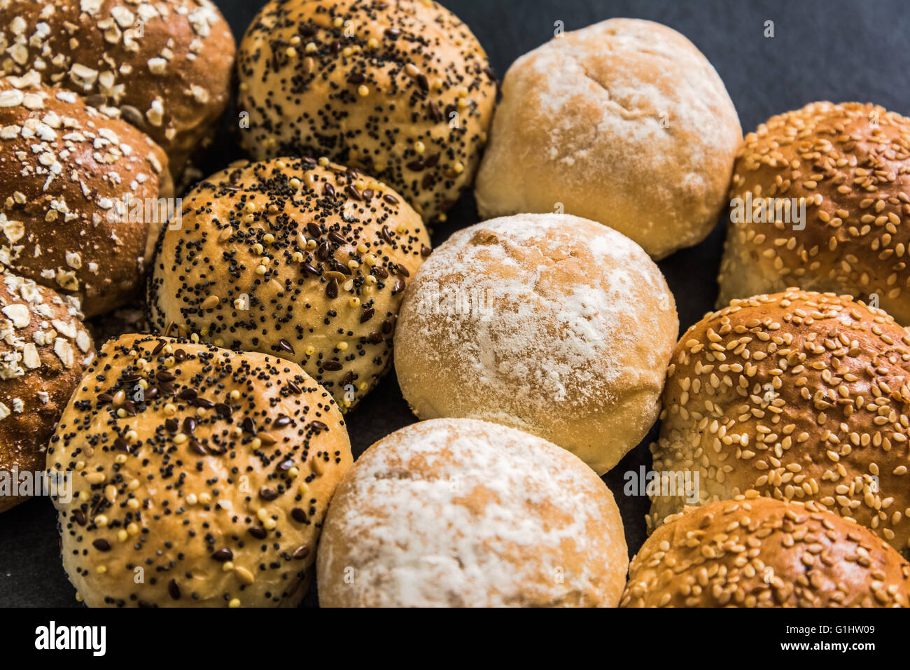 Artisan bakery buns and rolls on dark slate background from above Stock ...
