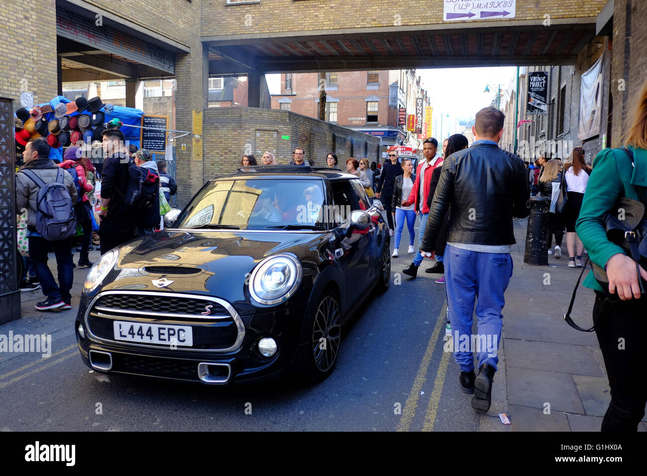 Mini cooper passing crowds on Brick Lane, London Stock Photo - Alamy