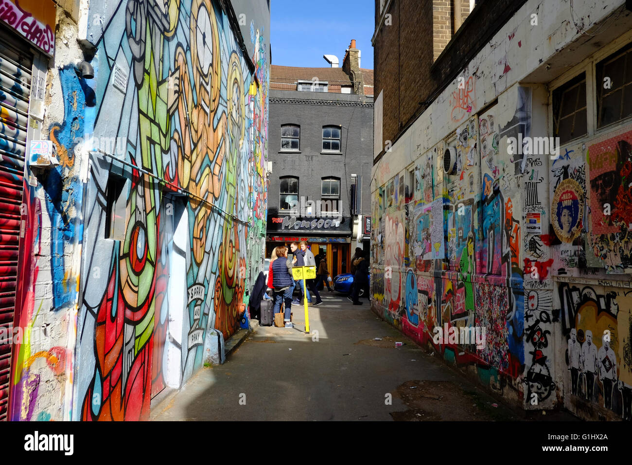 Tourist with baggage stop fro a break in a graffiti covered alley in ...