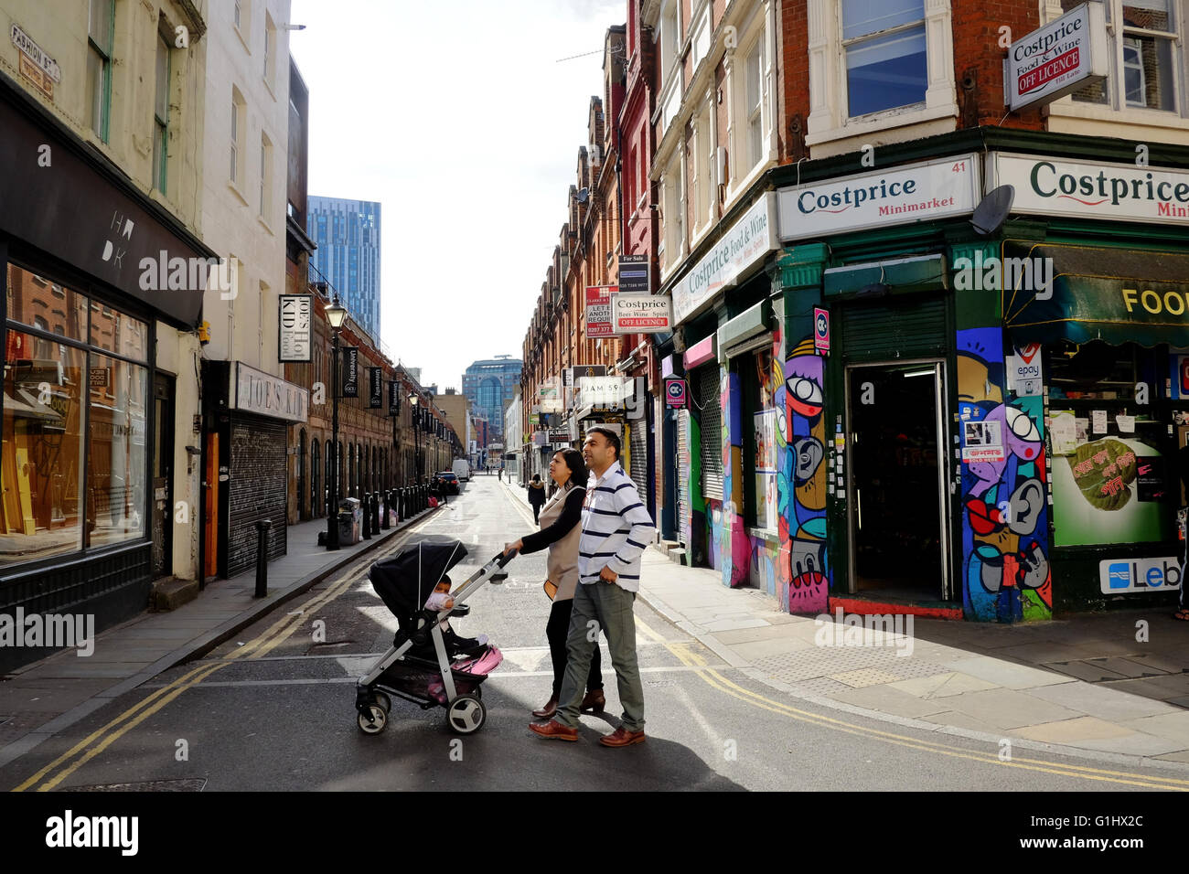 Asian couple with baby in pushchair crossing road in East London Stock ...