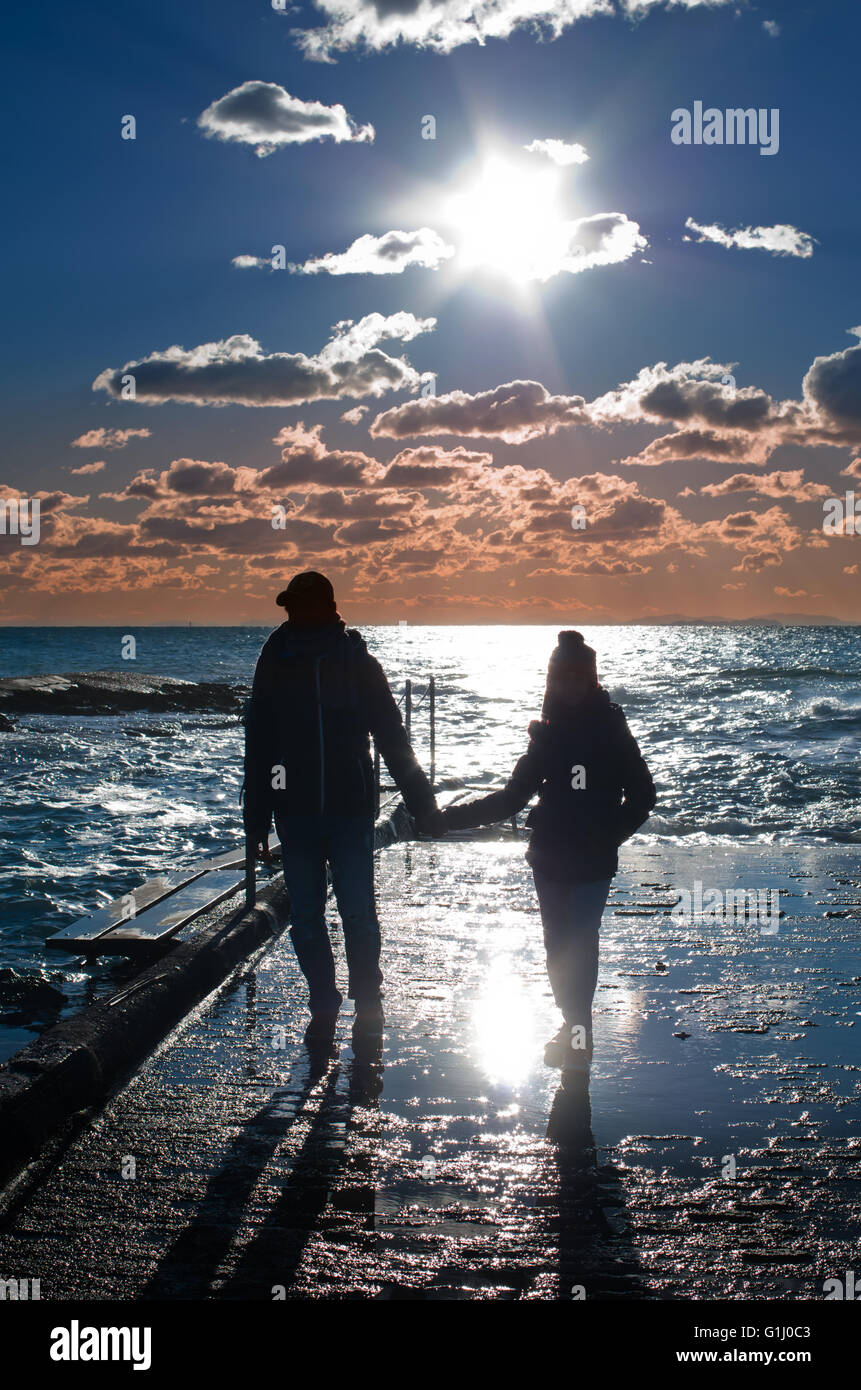 two people watching the sunset who goes to sleep in the sea Stock Photo ...