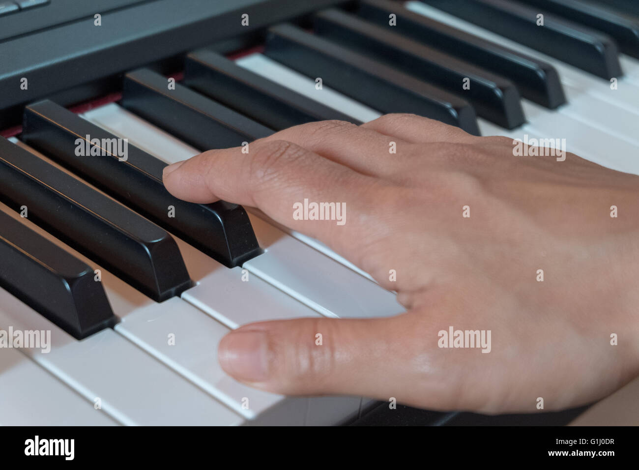 A hand playing piano keyboard Stock Photo - Alamy