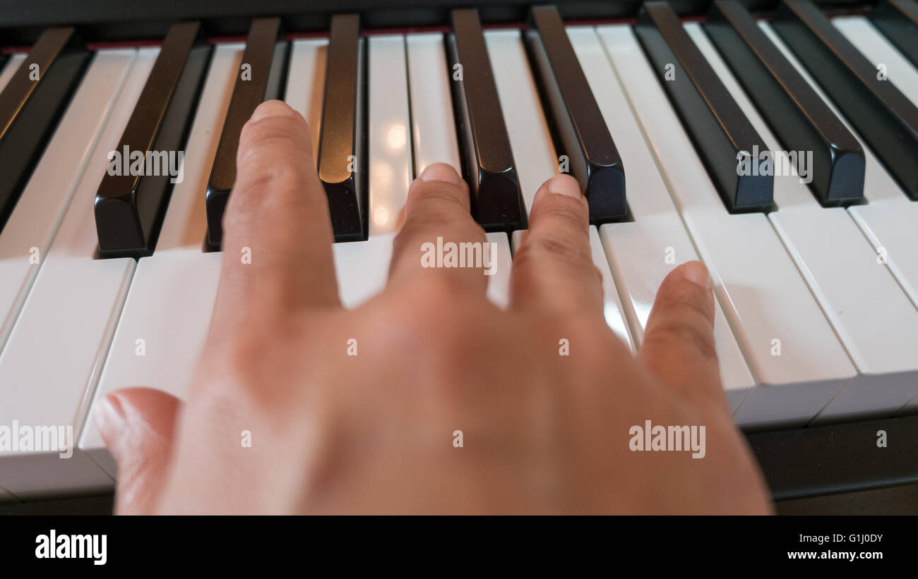A hand playıng piano keyboard Stock Photo - Alamy