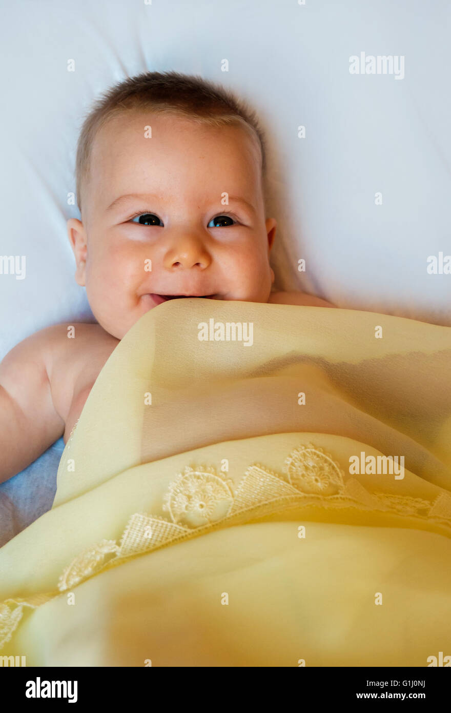 Baby in yellow blanket on a white background Stock Photo - Alamy