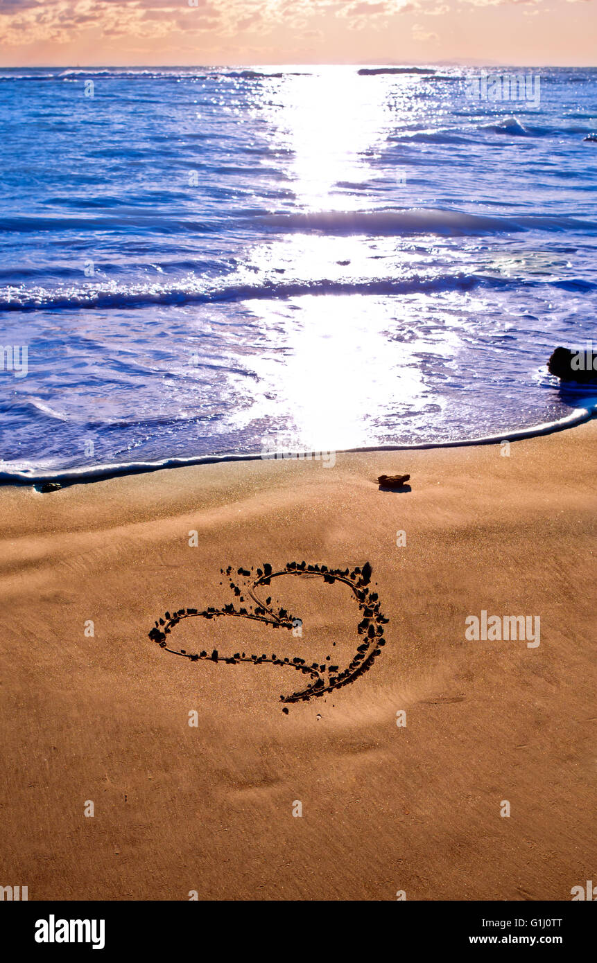 a heart waiting for you on the beach by the sea lit by the sunset Stock ...