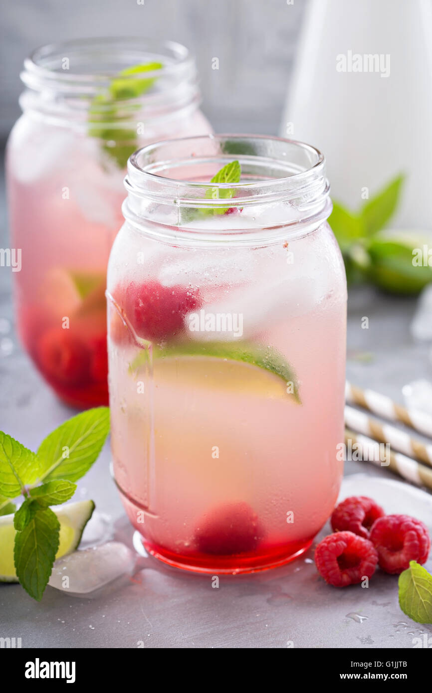 Cold green iced tea with lime and raspberry Stock Photo - Alamy