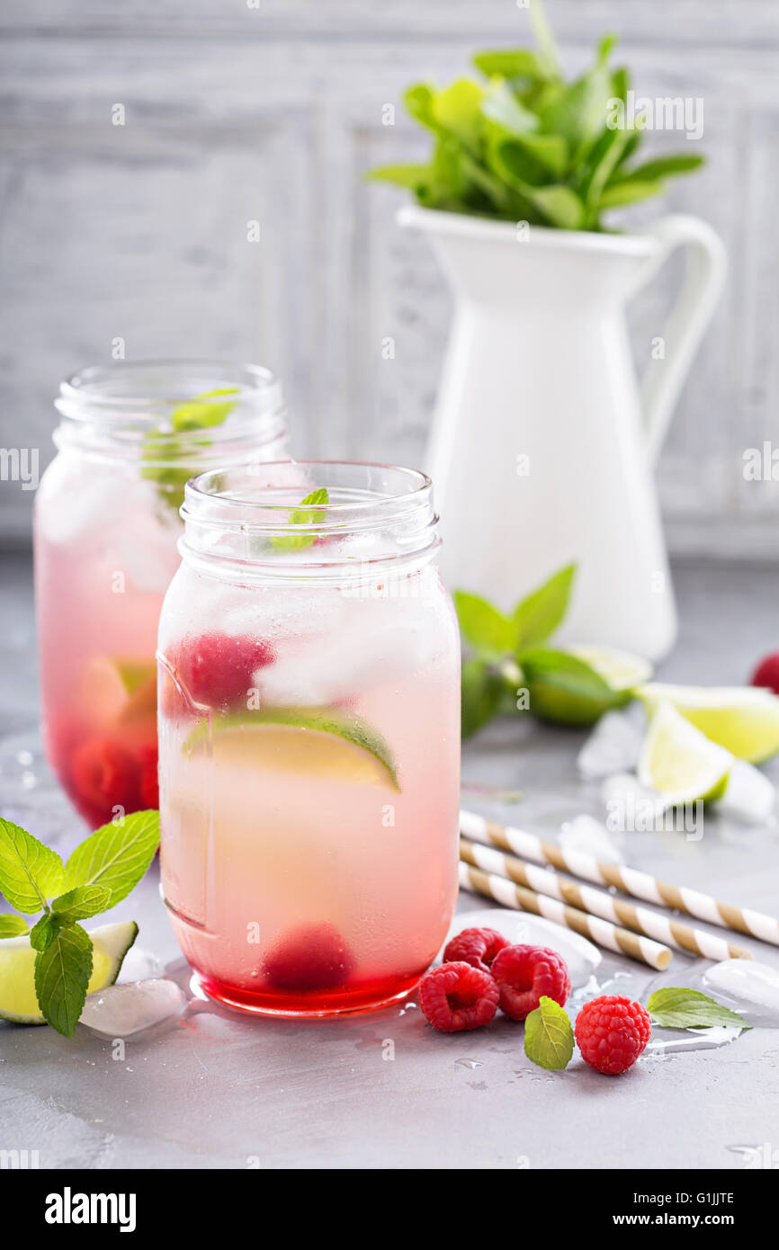 Cold green iced tea with lime and raspberry Stock Photo - Alamy