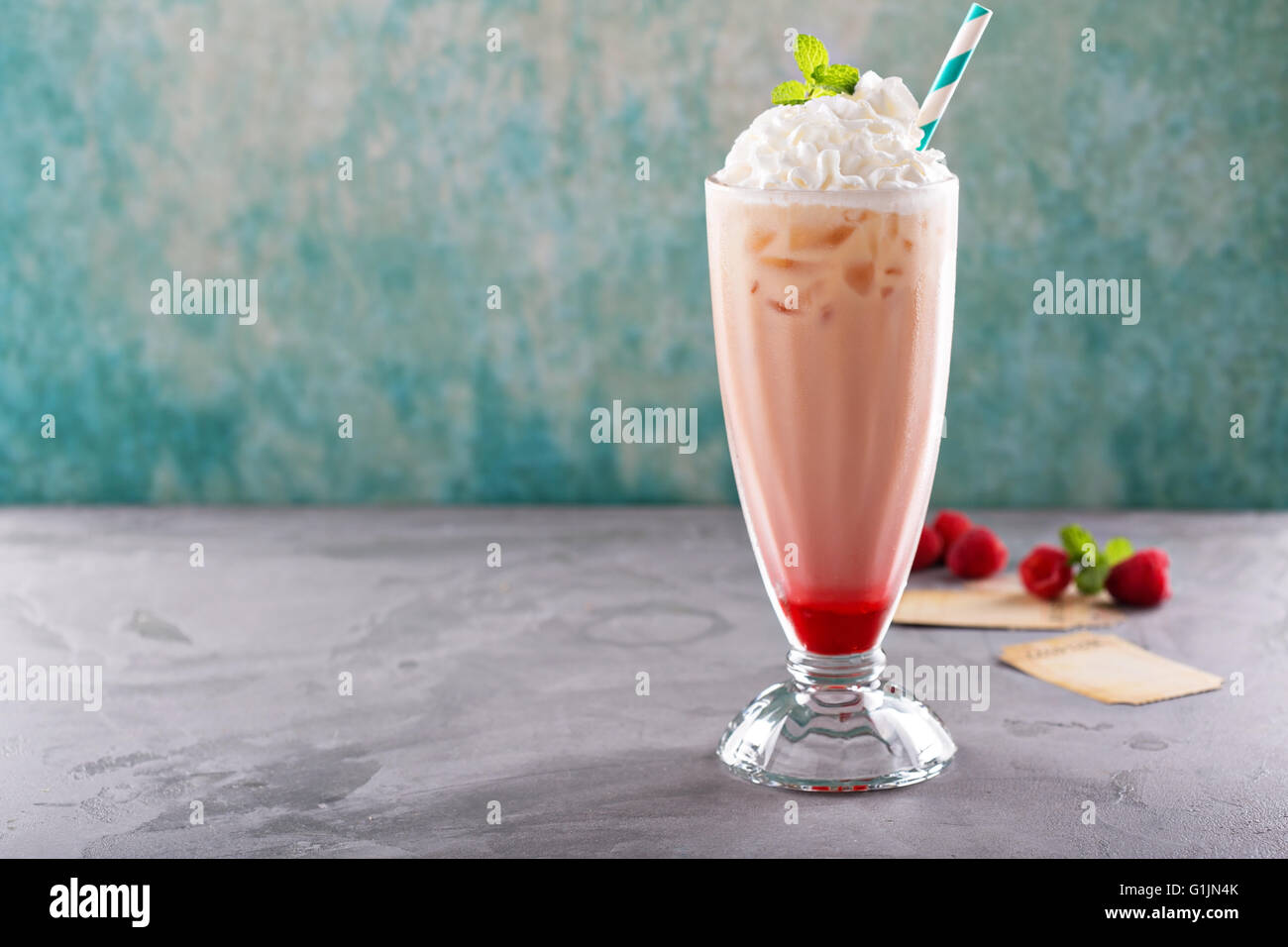 Iced milkshake with raspberry syrup and whipped cream Stock Photo - Alamy