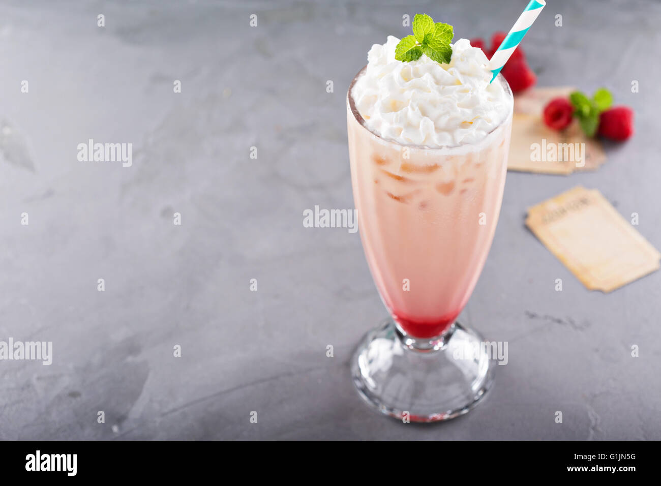 Iced milkshake with raspberry syrup and whipped cream Stock Photo - Alamy
