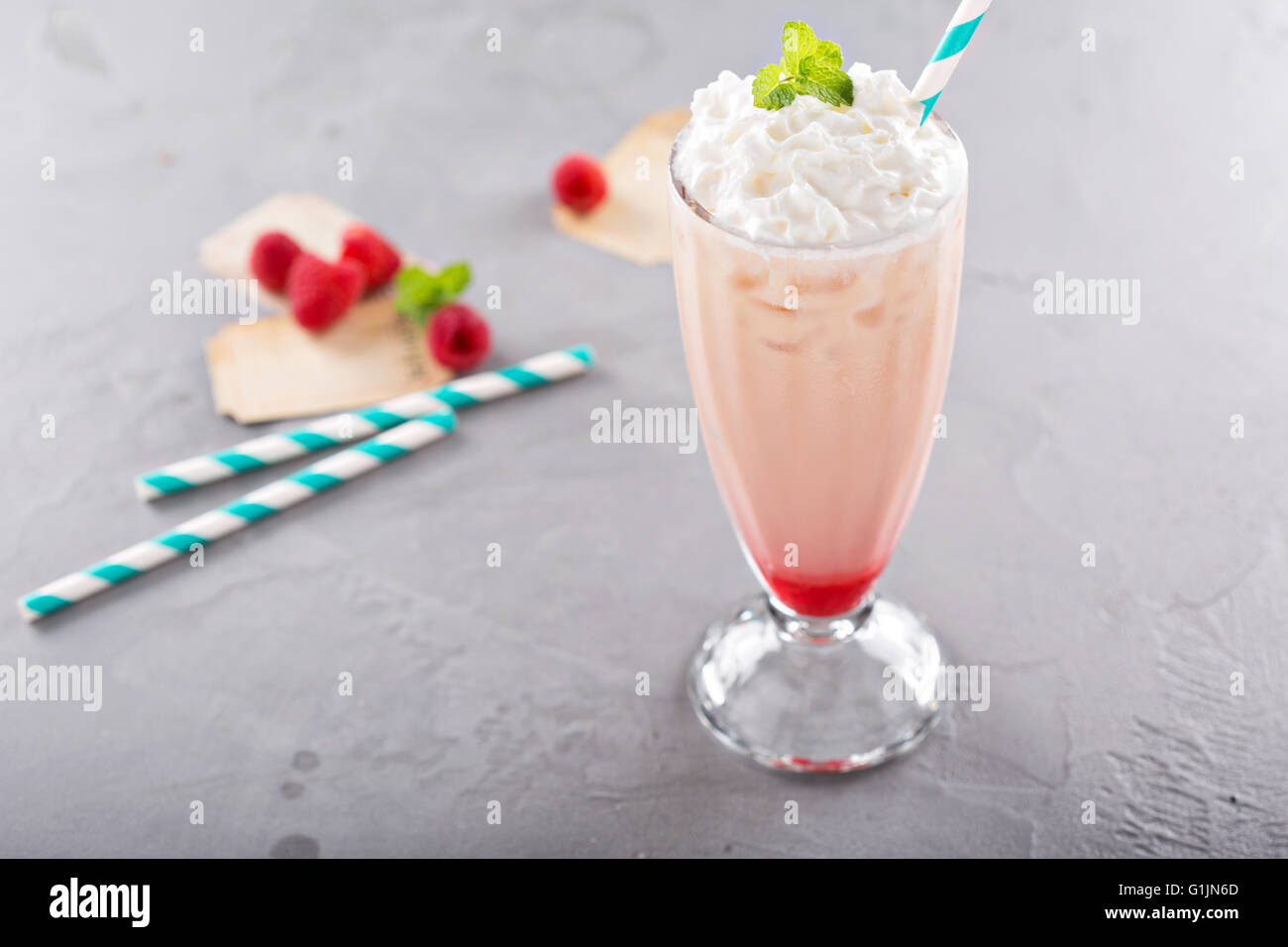 Iced milkshake with raspberry syrup and whipped cream Stock Photo - Alamy