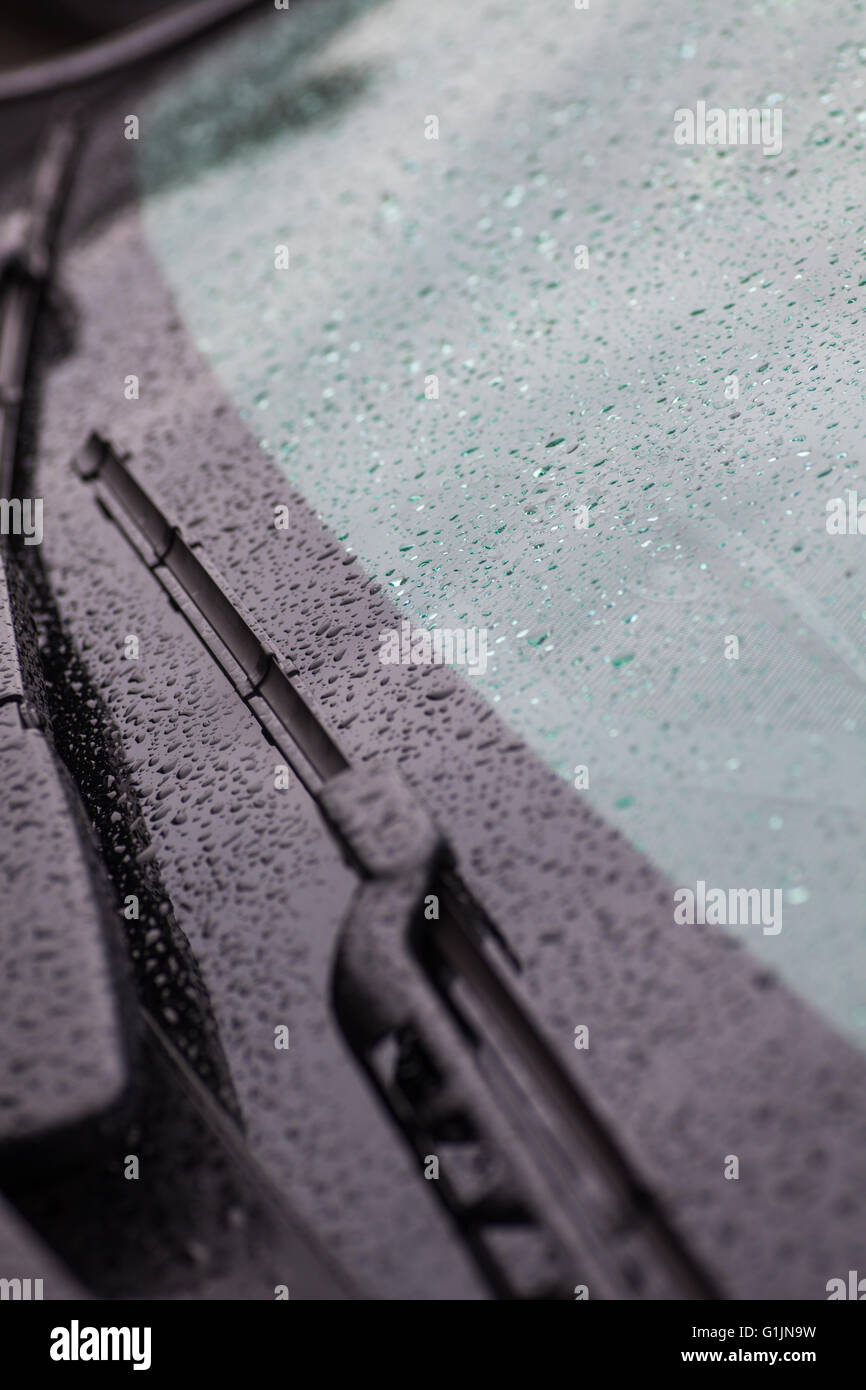 Color image of the wipers of a car, with rain drops on the windshield ...
