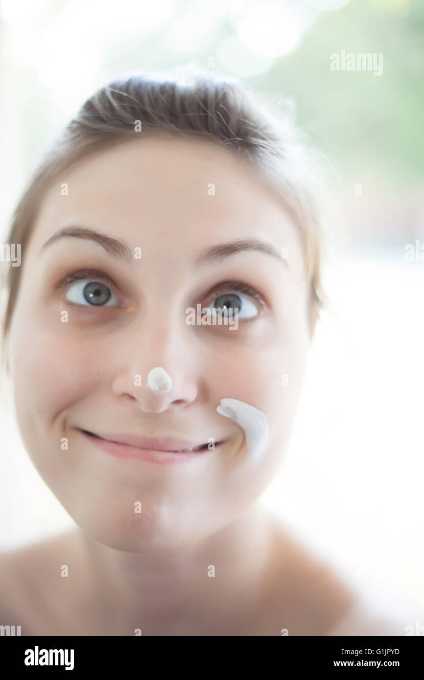 High key portrait of young women decorating her home making funny face ...