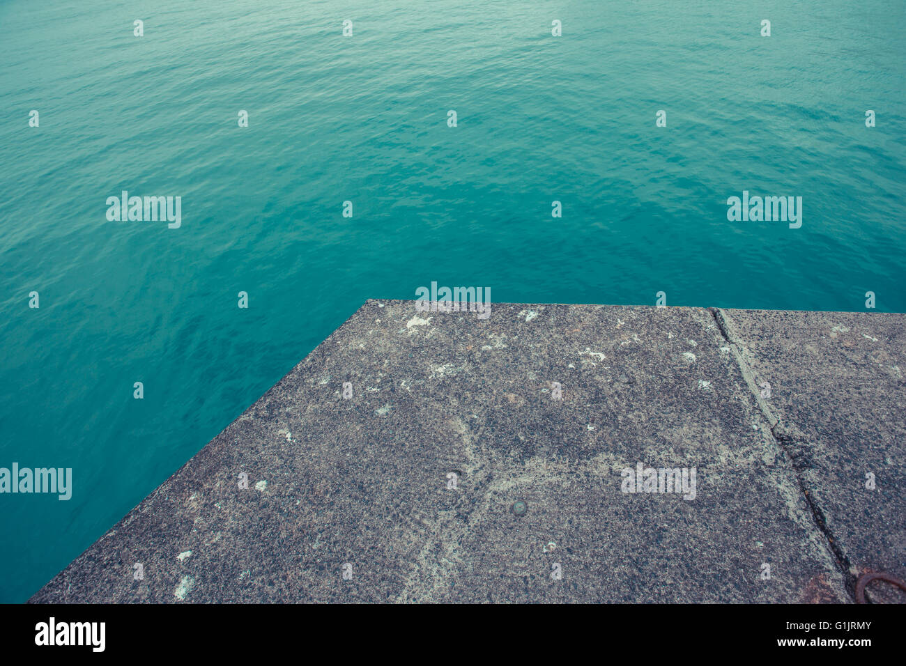 Concrete jetty and water below it in a harbour Stock Photo - Alamy