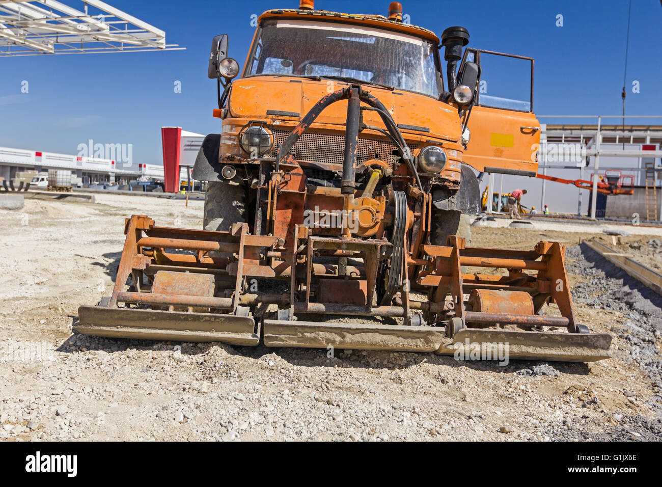Plate compactor is mounted to the truck, compacting sand at road ...