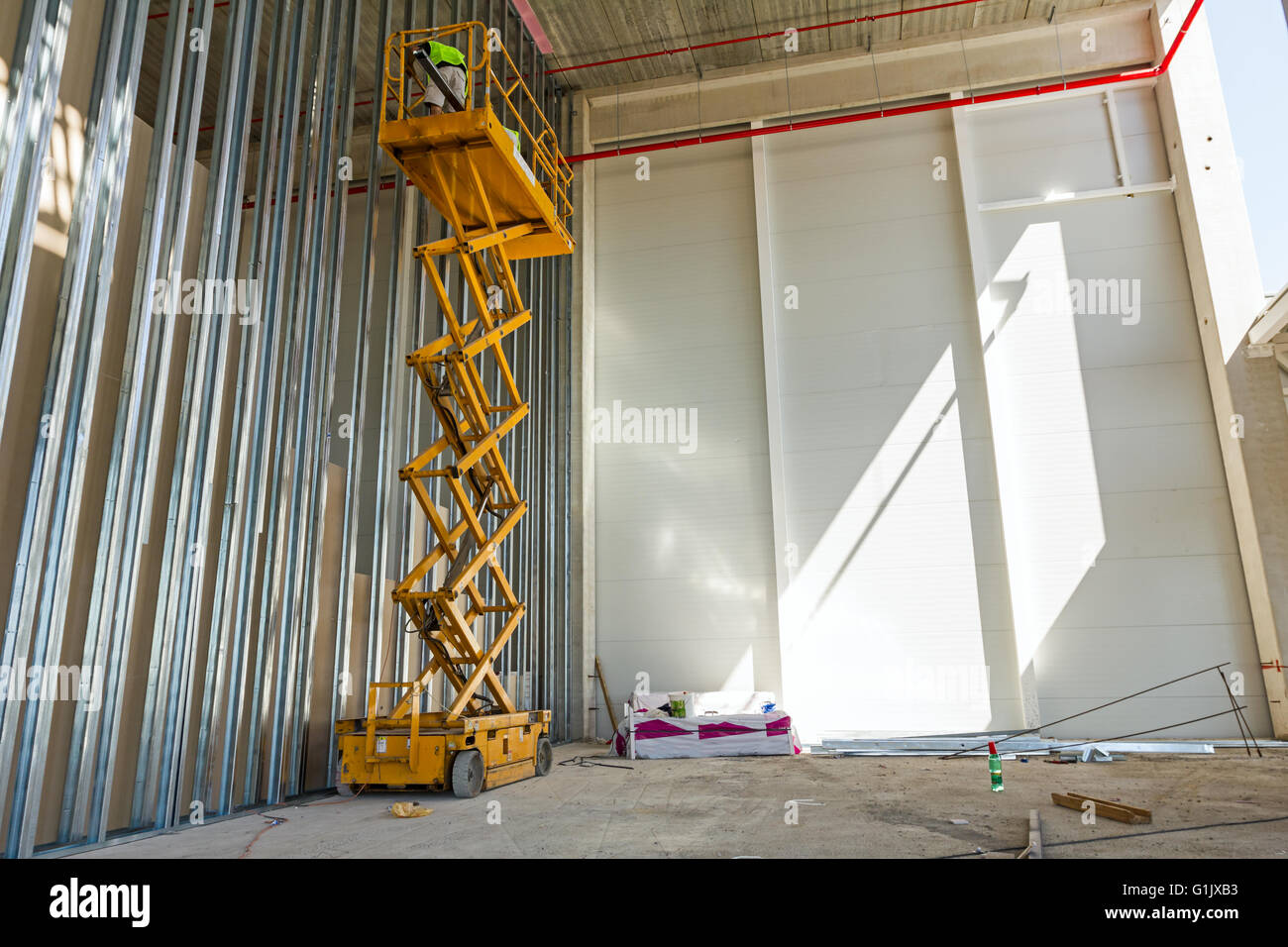 Workers are high up in cherry picker on building site Stock Photo - Alamy
