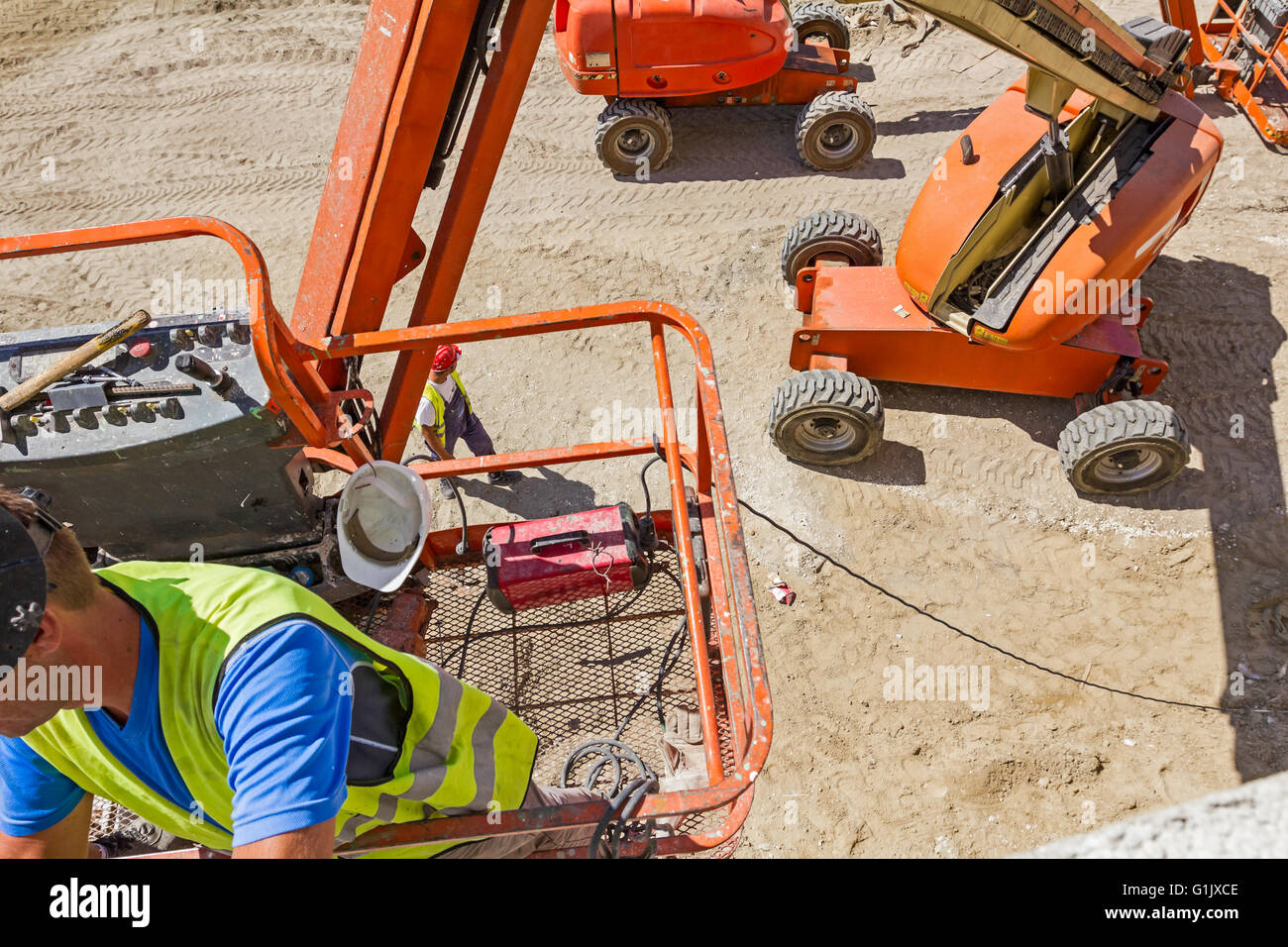 High elevated cherry picker with team of workers on construction site ...