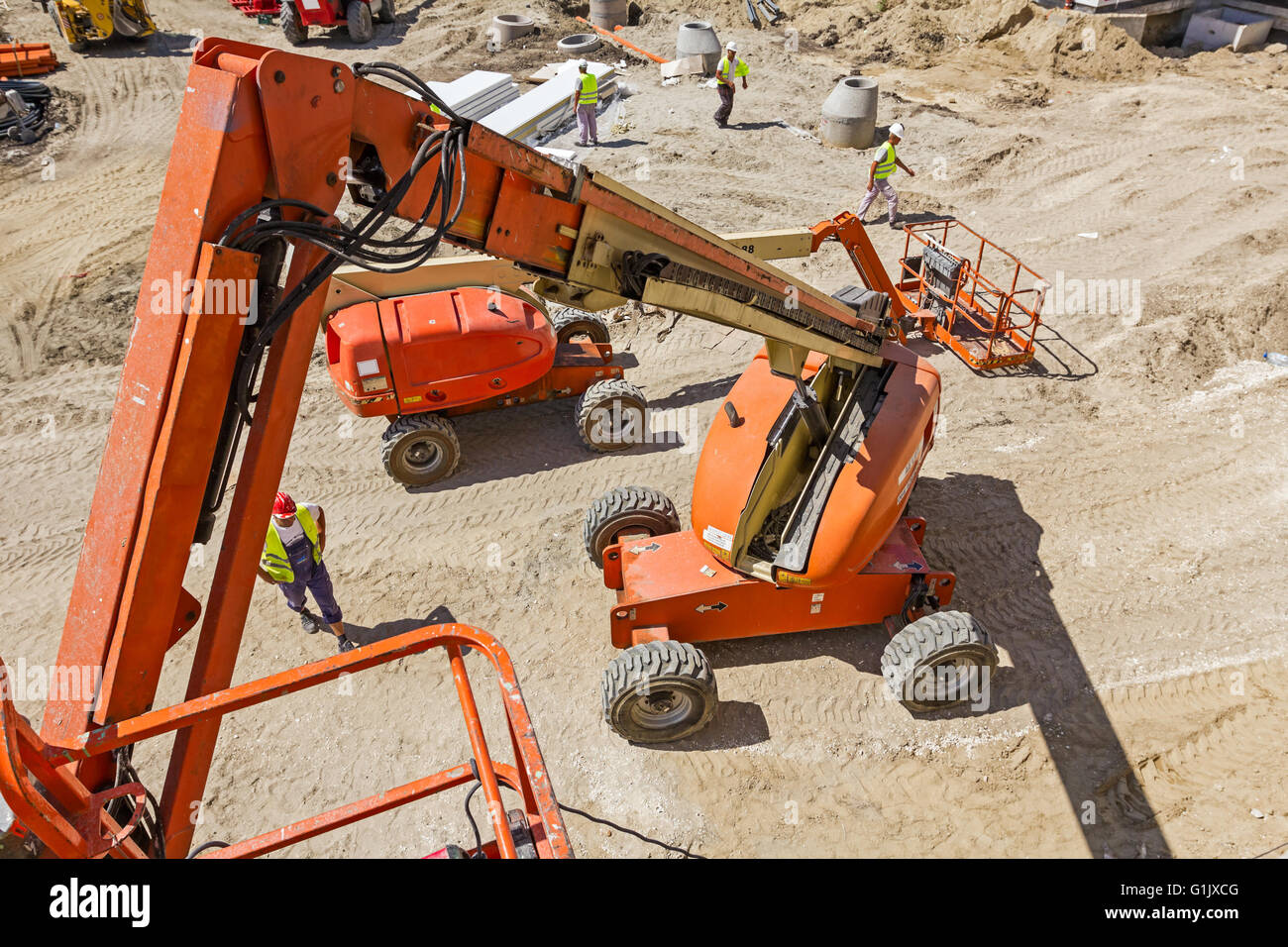 High elevated cherry picker with team of workers on construction site ...
