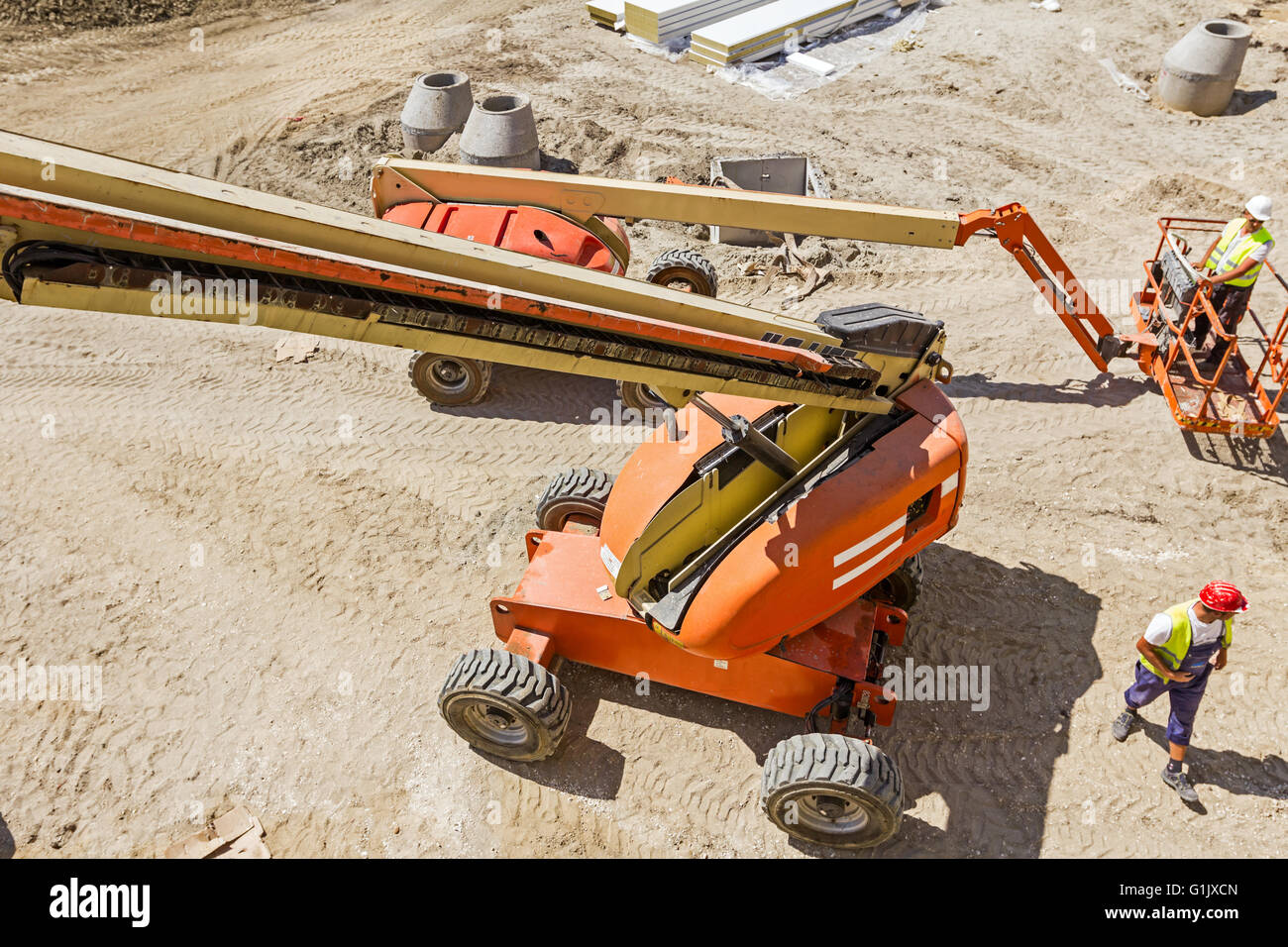 High elevated cherry picker with team of workers on construction site ...