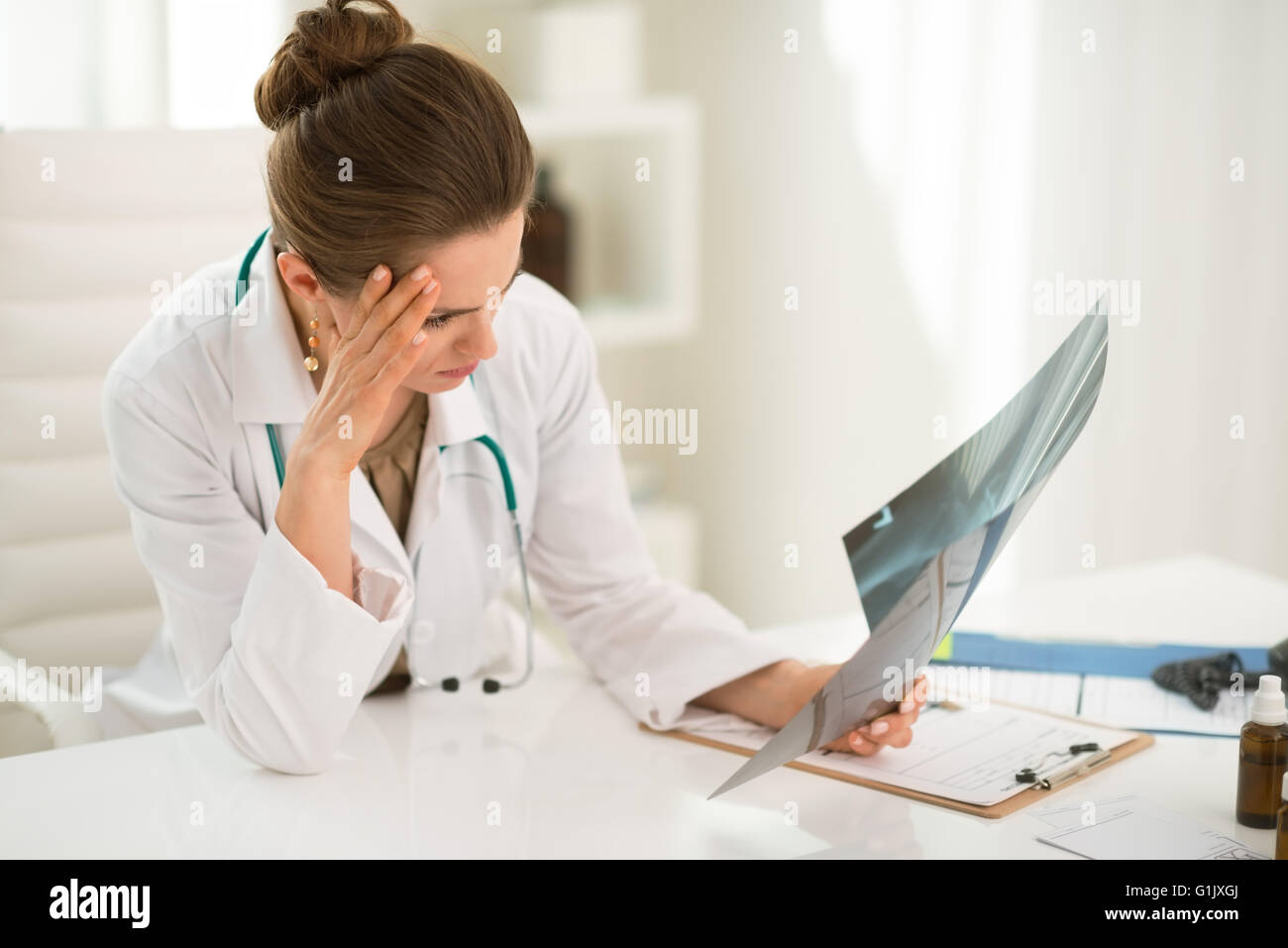 Modern health care. Concerned female doctor sitting at a desk in the ...